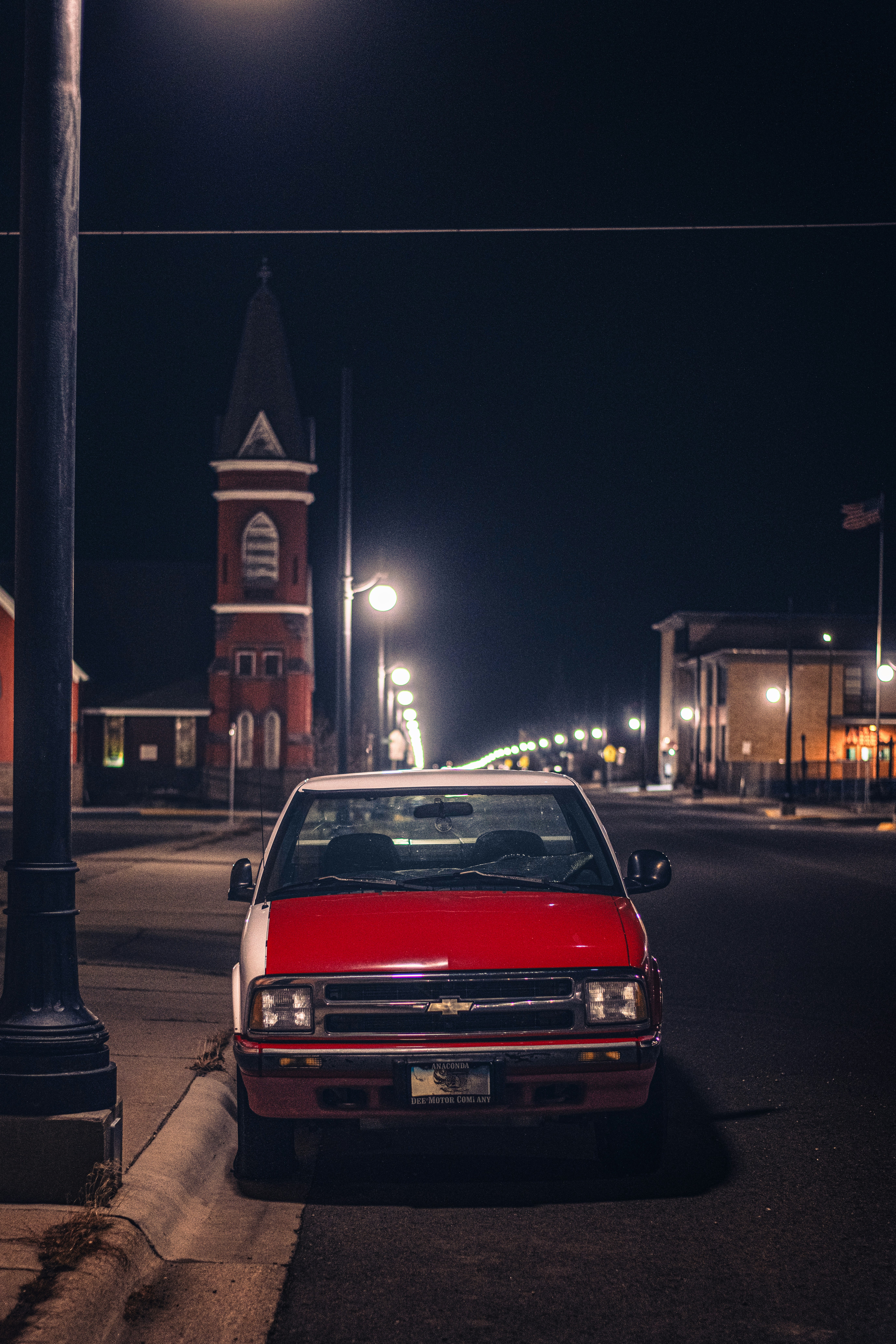 Crimson Pickup under Quiet Streetlamps: A Night in Small-Town Stillness