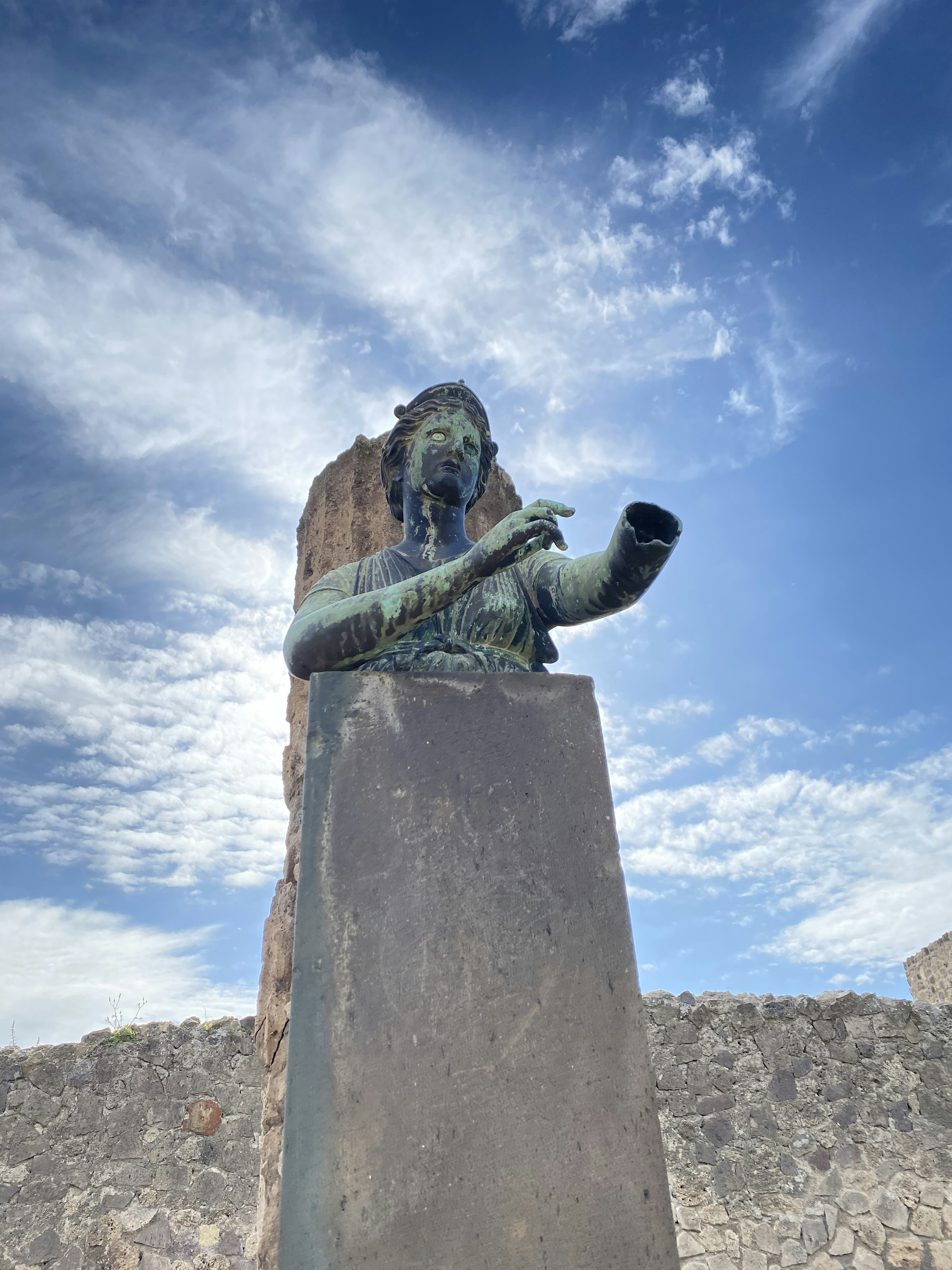 Bronze Sentinel Reaching Toward the Sky Over a Crumbling Wall