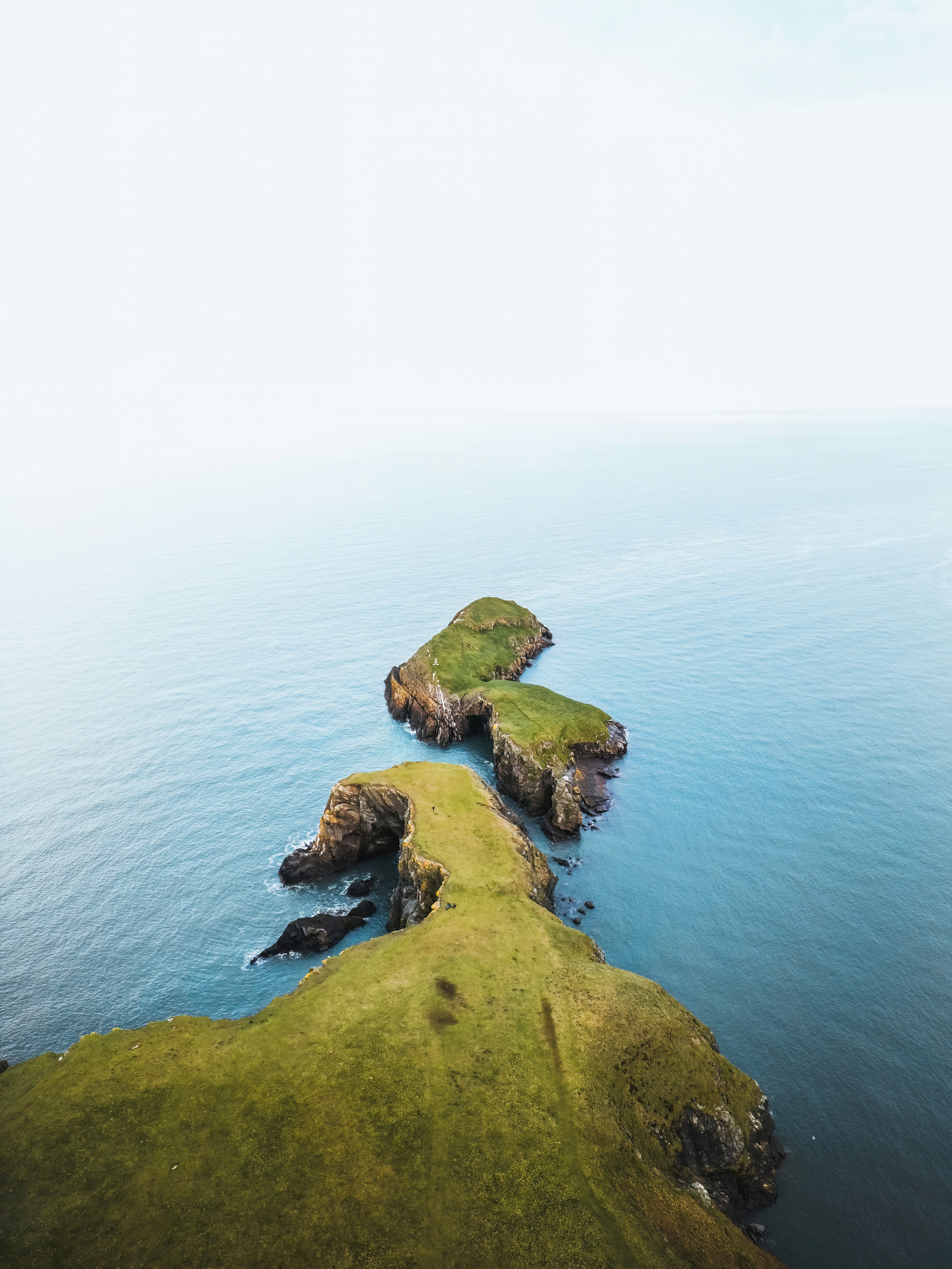 A couple of small islands in the middle of a body of water photo – Free ...