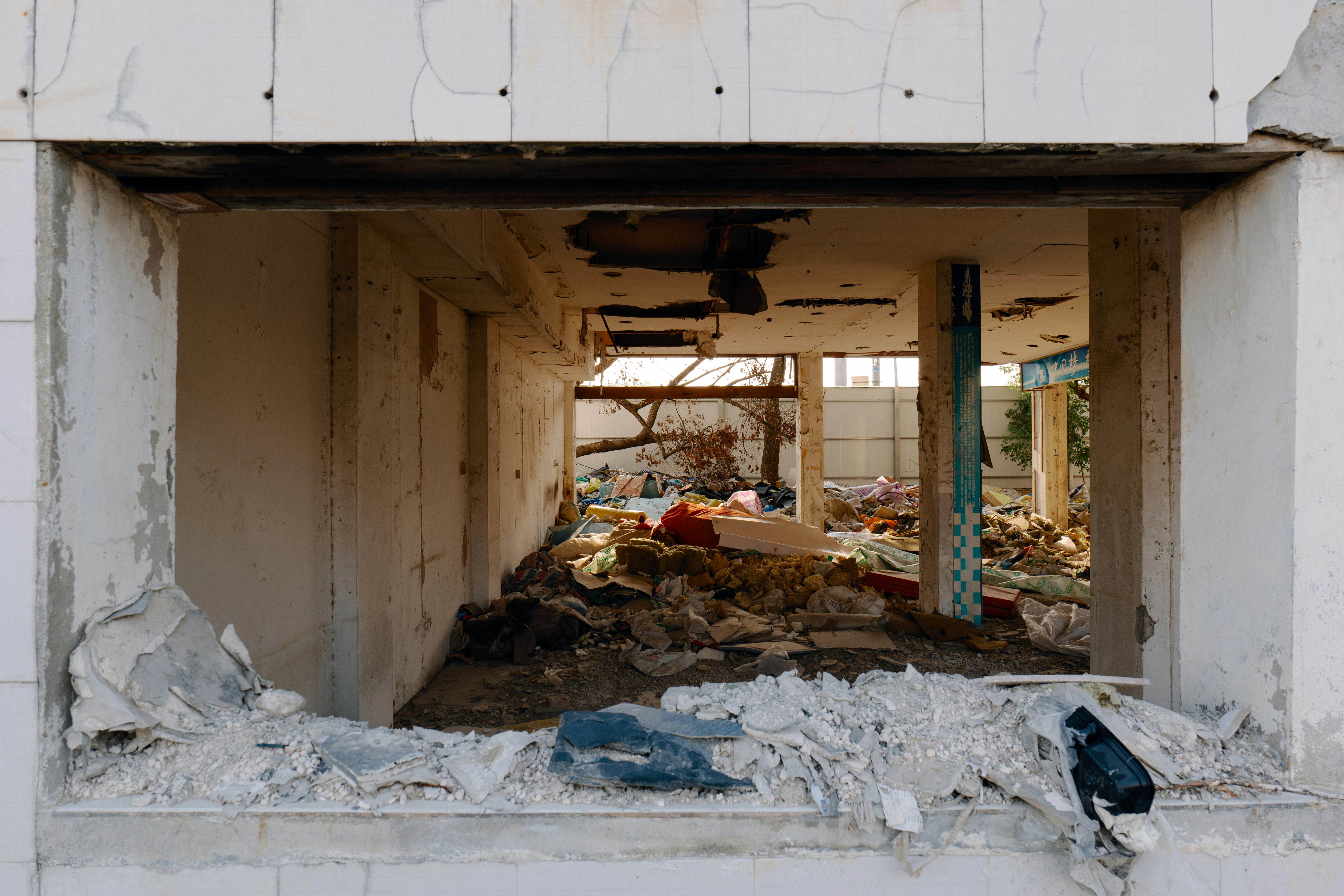 A demolished building with a broken window and a pile of rubble photo ...