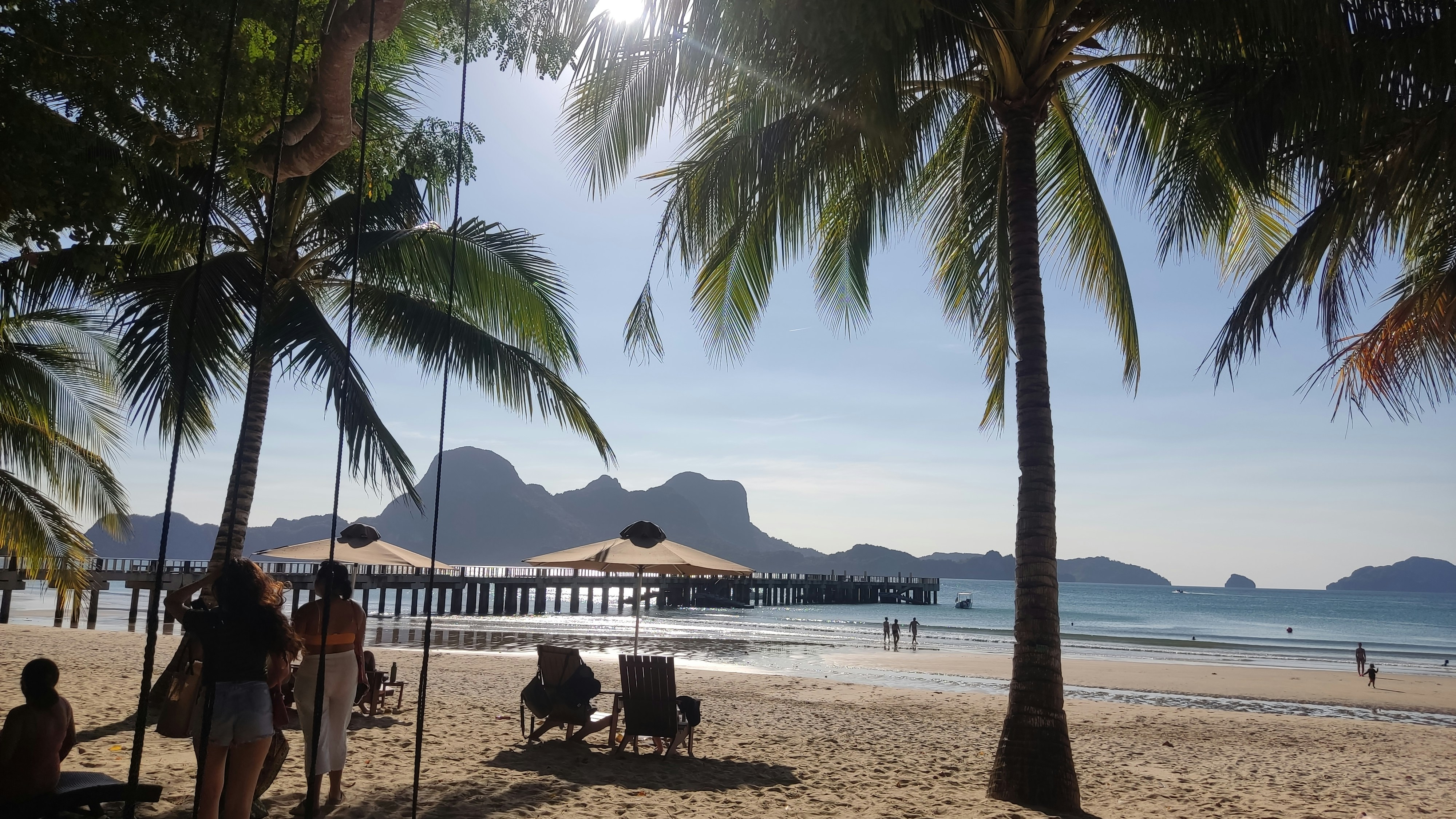 A group of people standing on top of a sandy beach photo – Free Beach ...