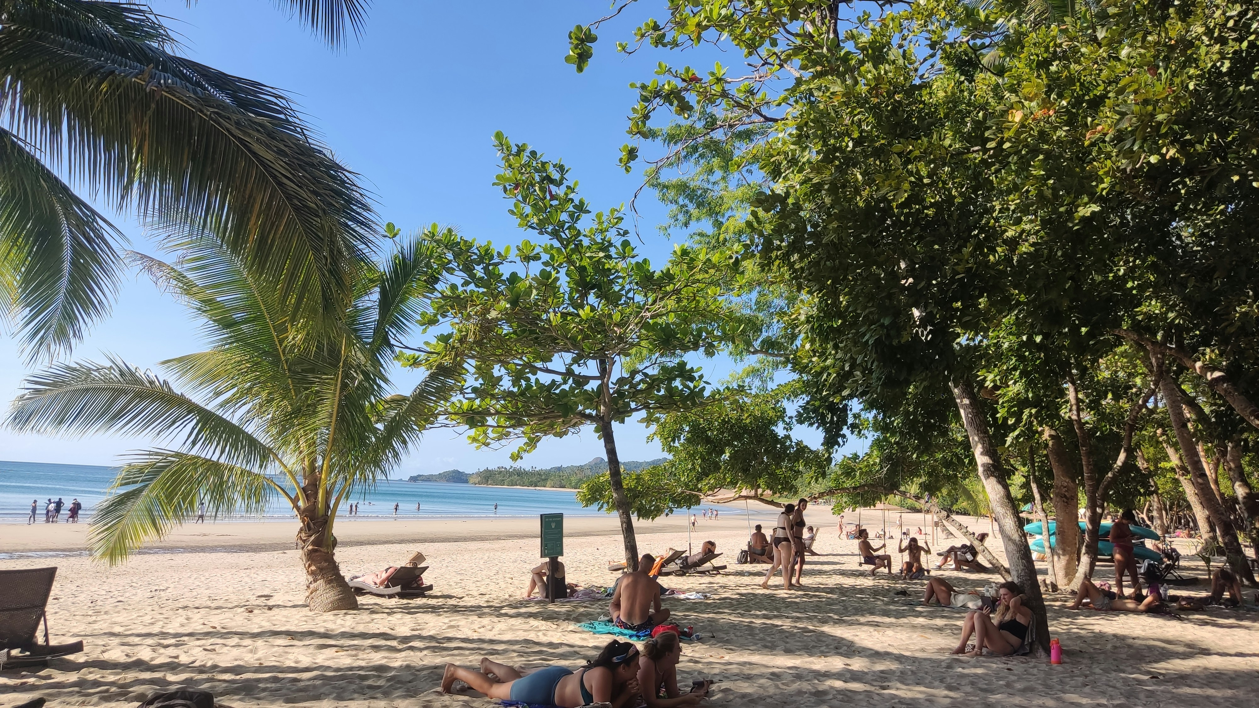 A group of people sitting on top of a sandy beach photo – Free Summer ...
