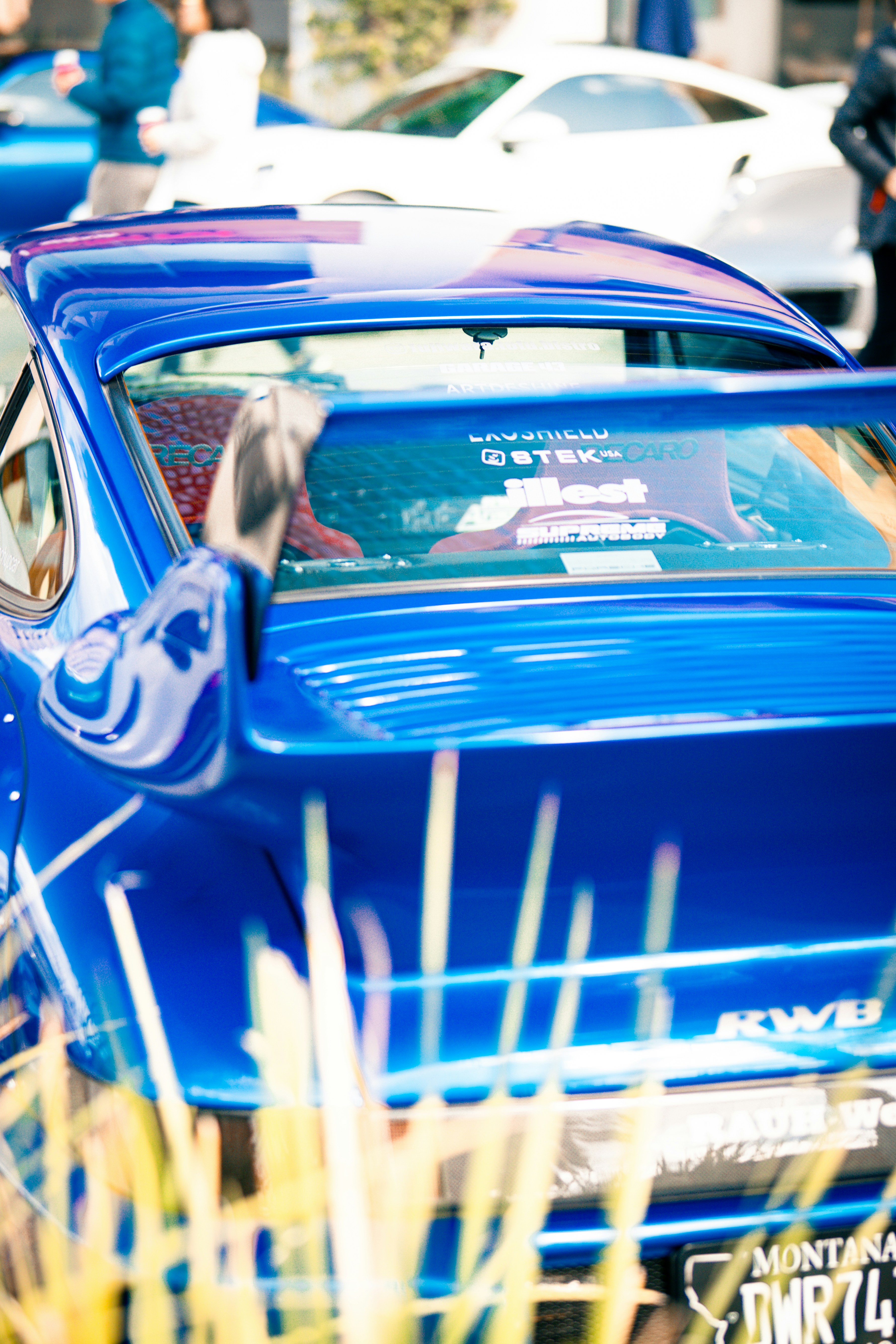 Cobalt Mirage: a blue racing silhouette amid a city car-show crowd