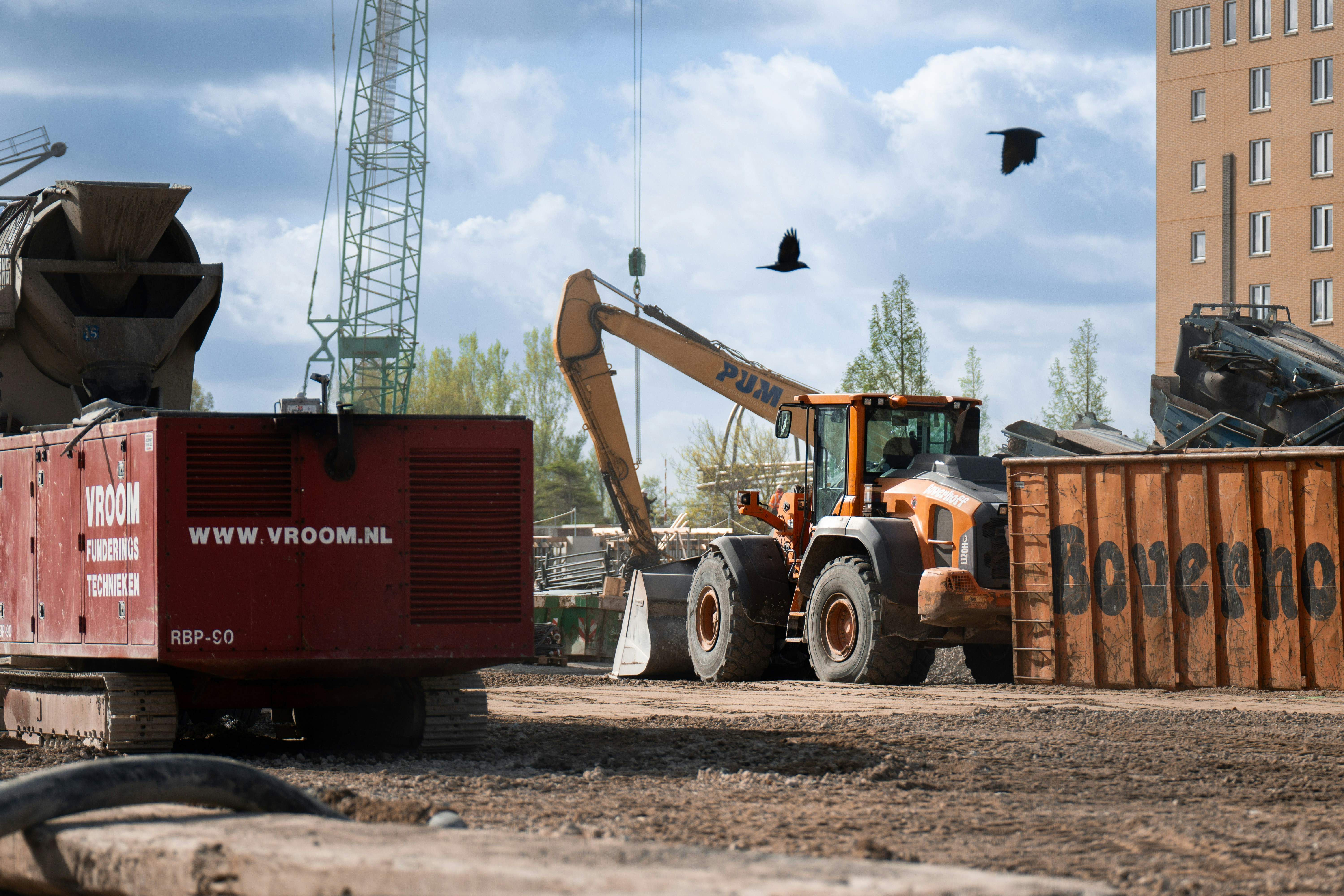 A construction site with a dump truck and a crane photo – Free Worker ...