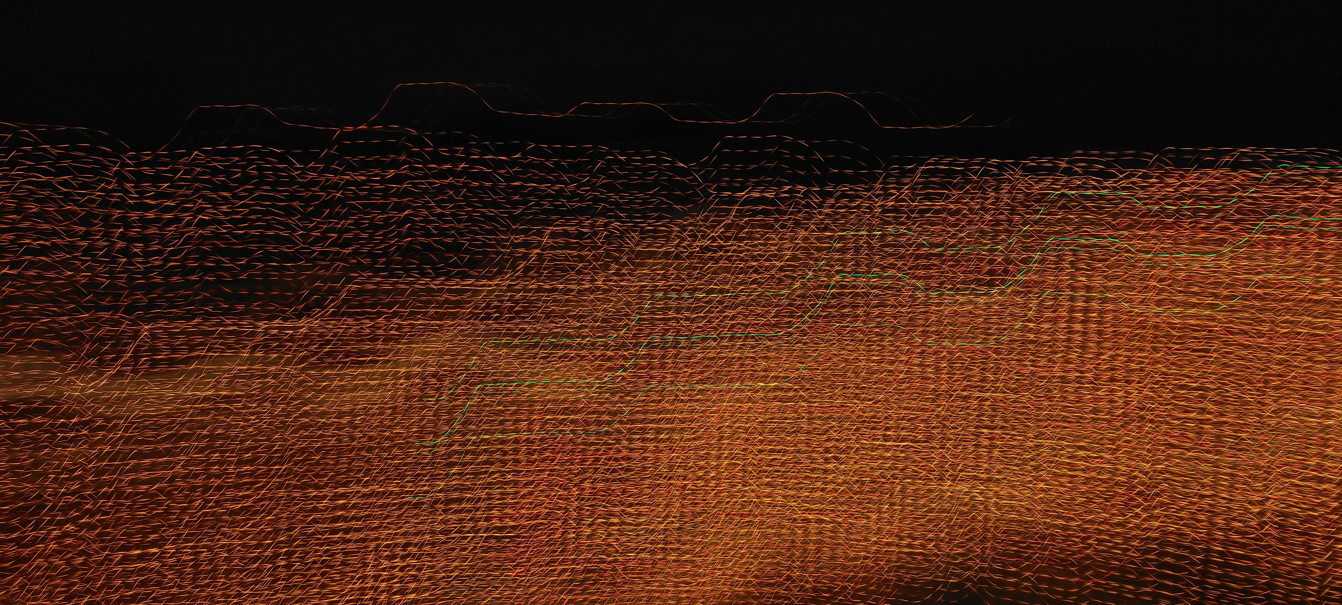 Close-up of an orange textured fabric with wavy ripples against a dark background.