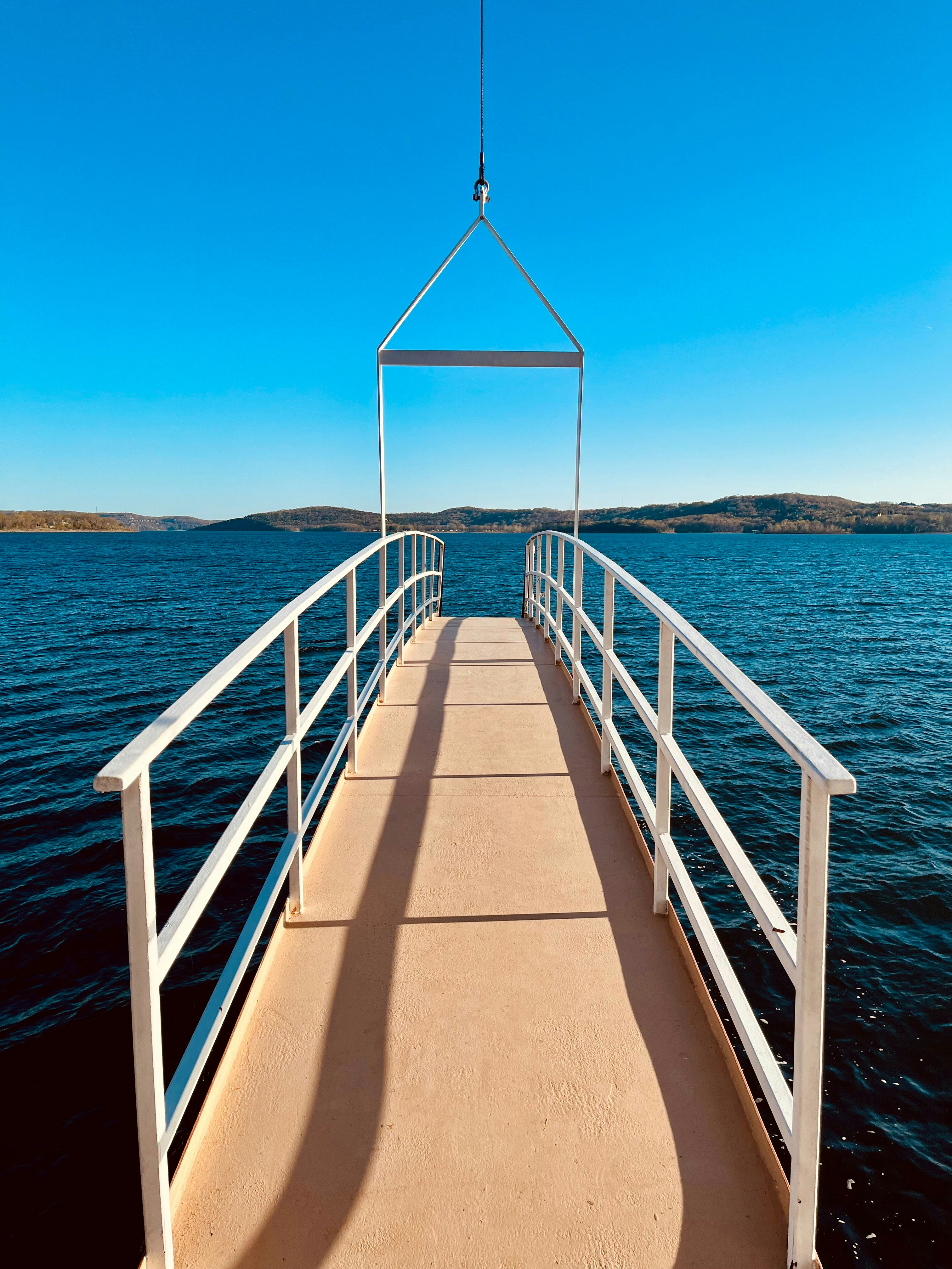 A boat dock with a metal railing and a clear blue sky photo – Free ...