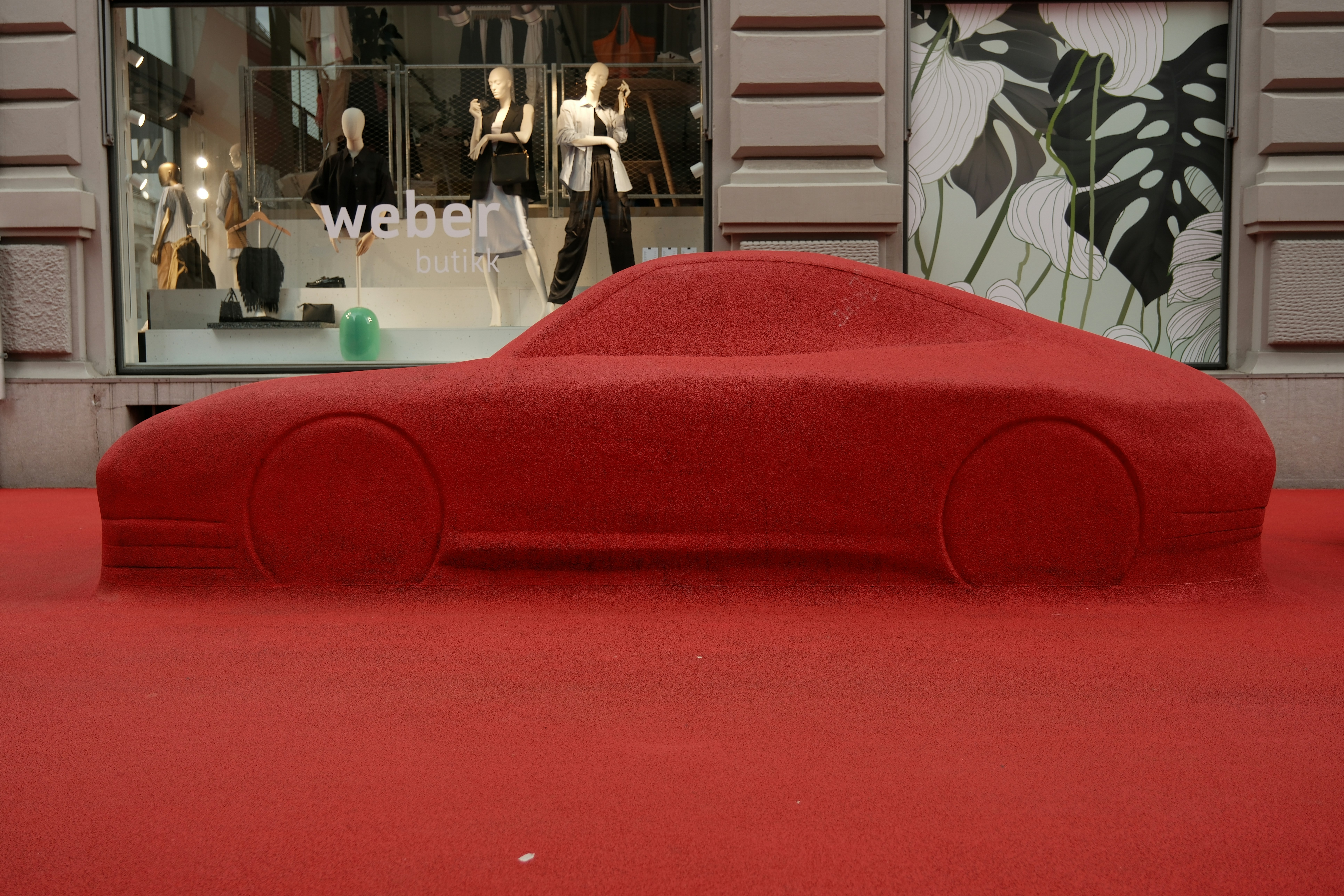 Red Car Sculpture Anchors a Fashion-Forward Window Scene