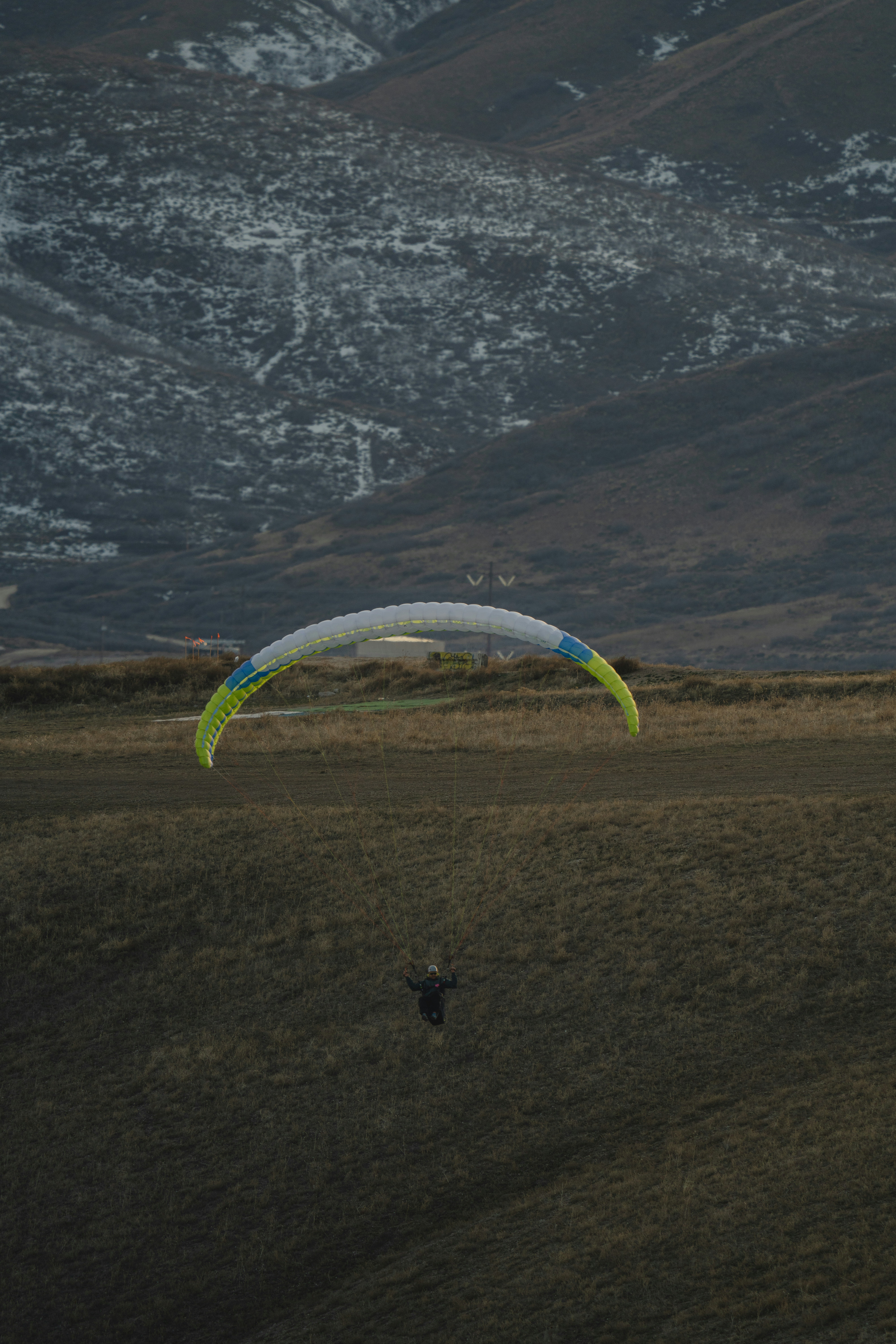 Paraglider taking off, flying in the mountains at sunset
