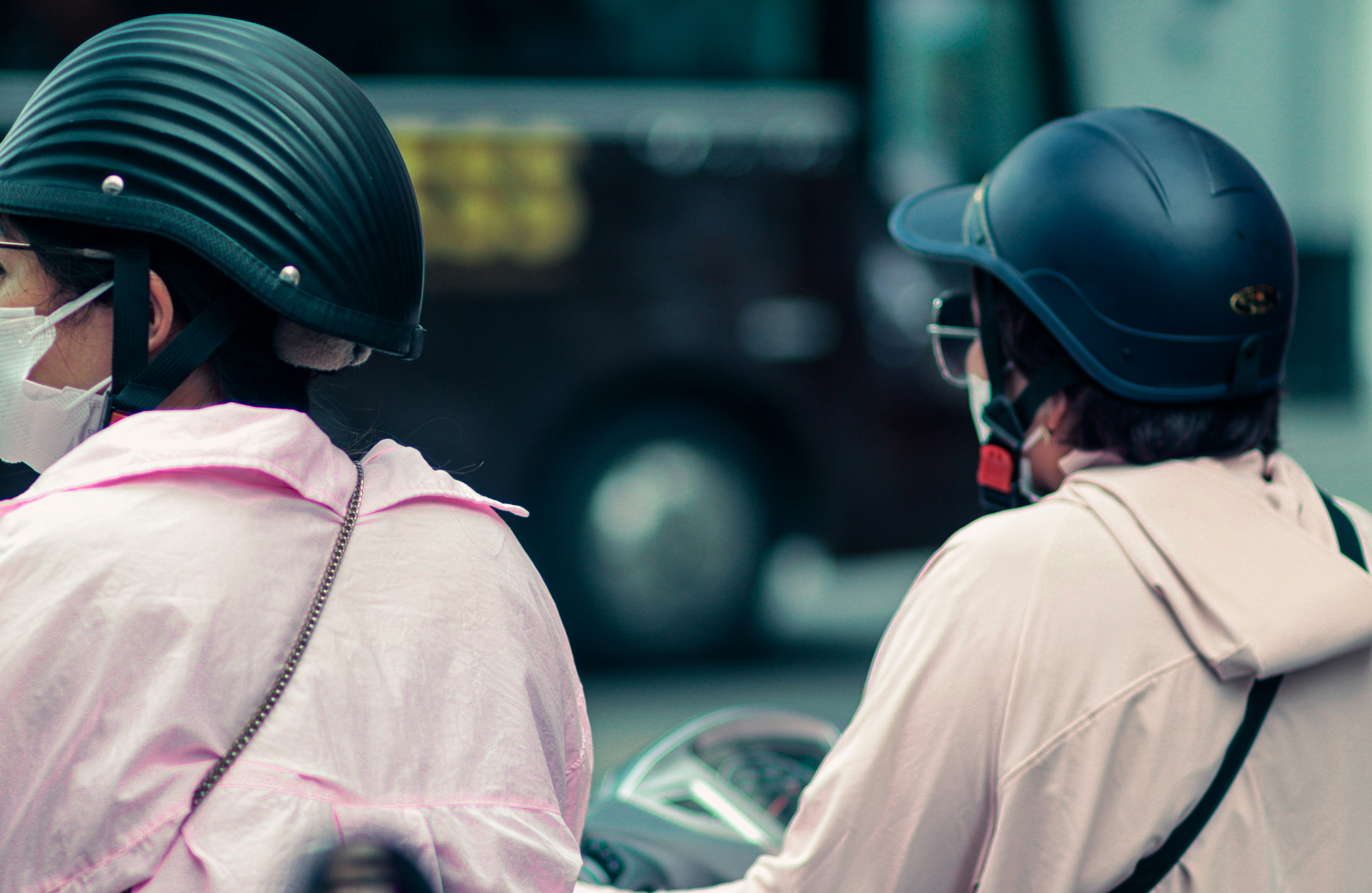Two Bike Riders in Protective Gear on an Urban Street