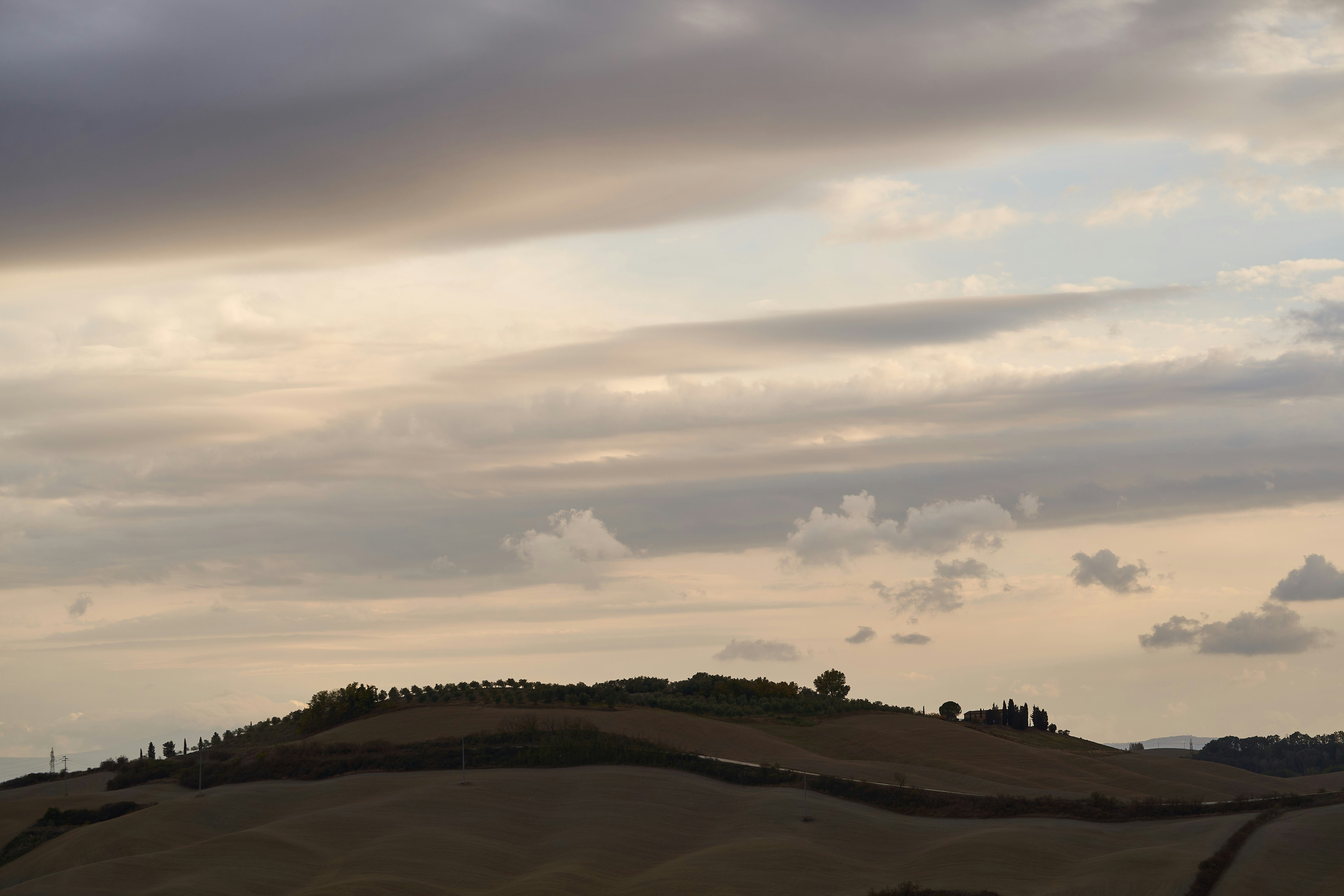 Une colline avec des arbres au sommet sous un ciel nuageux photo ...