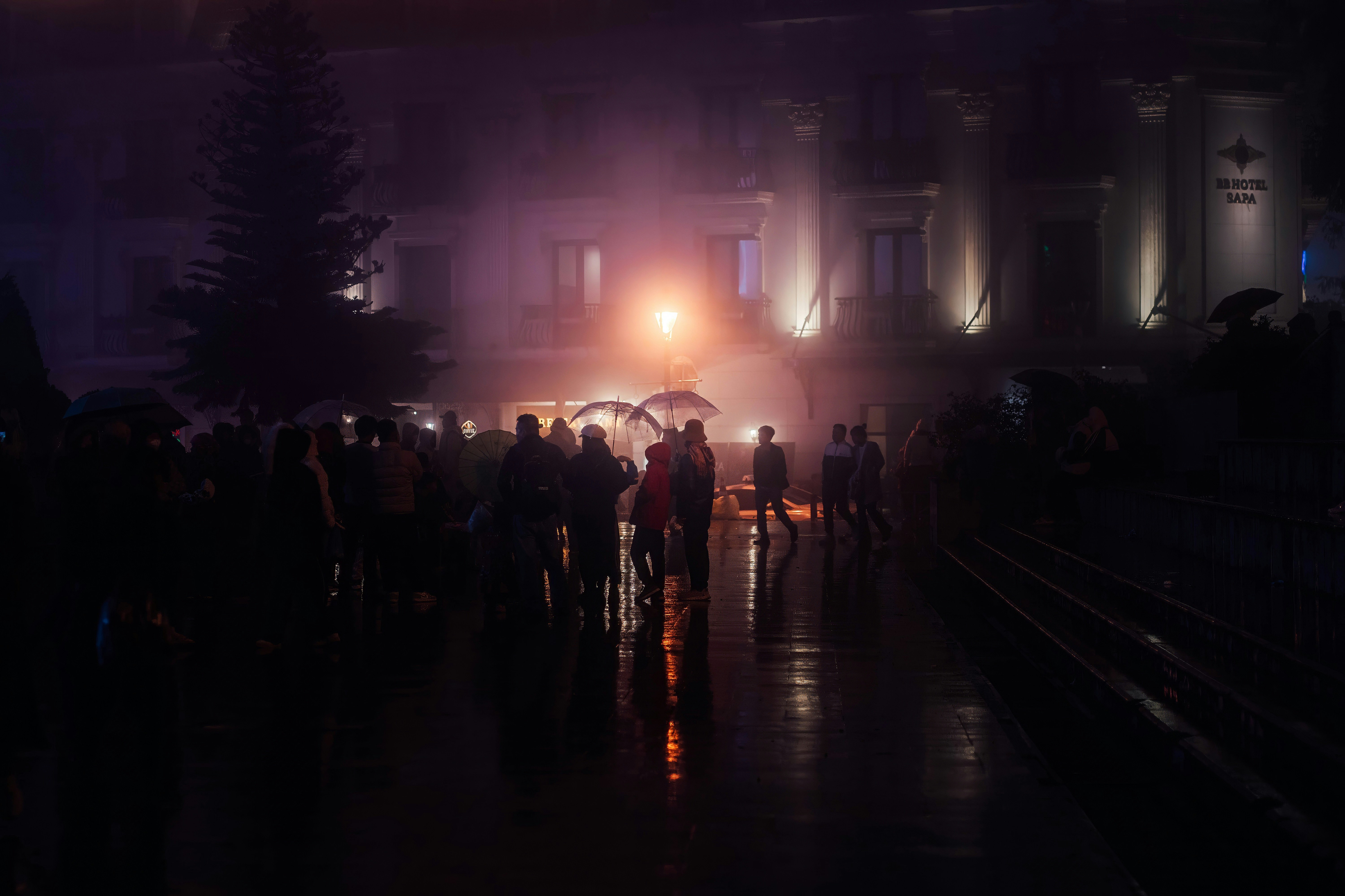 A group of people standing in the rain at night photo – Free People ...