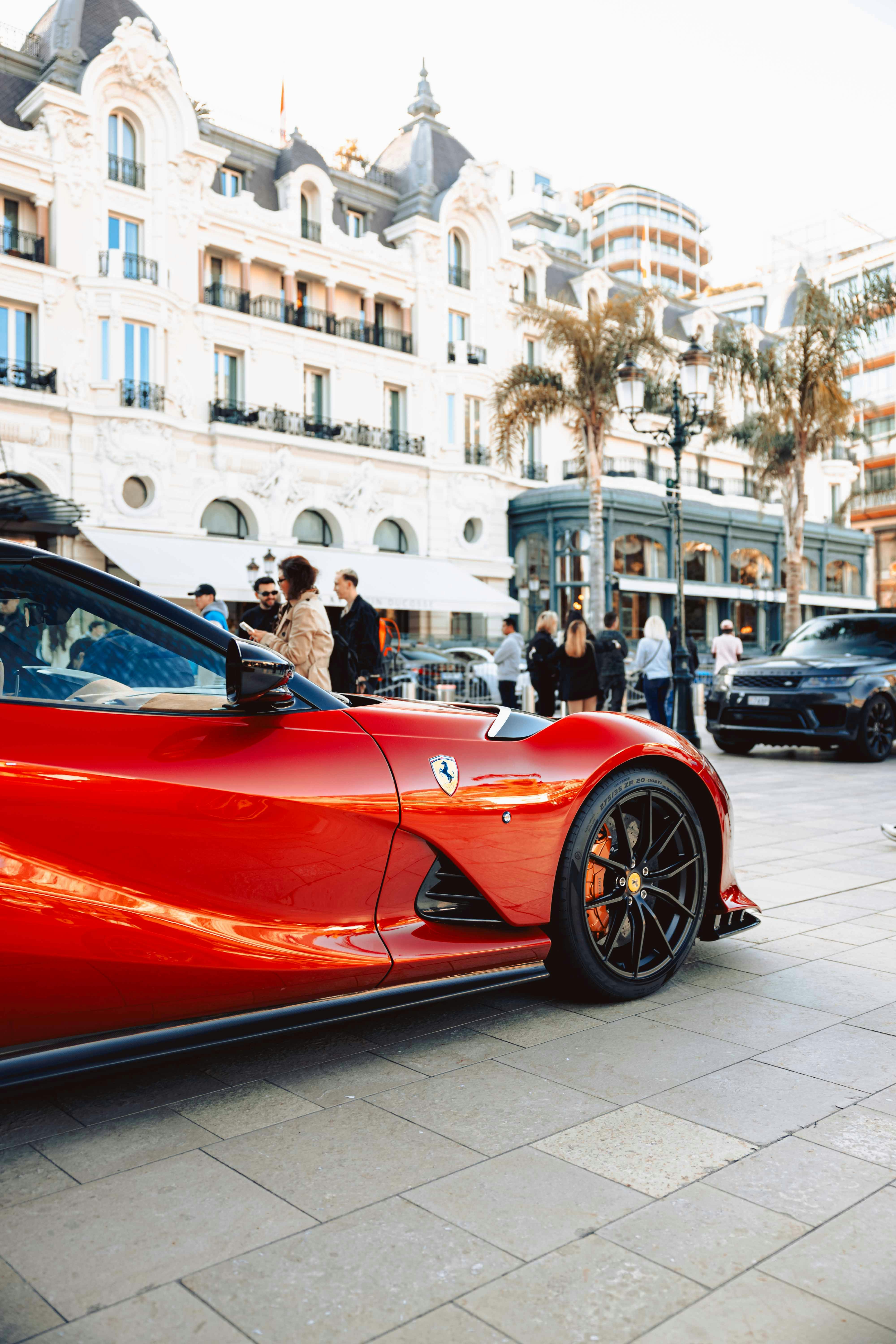 Sleek red Ferrari at a sunlit boulevard storefront