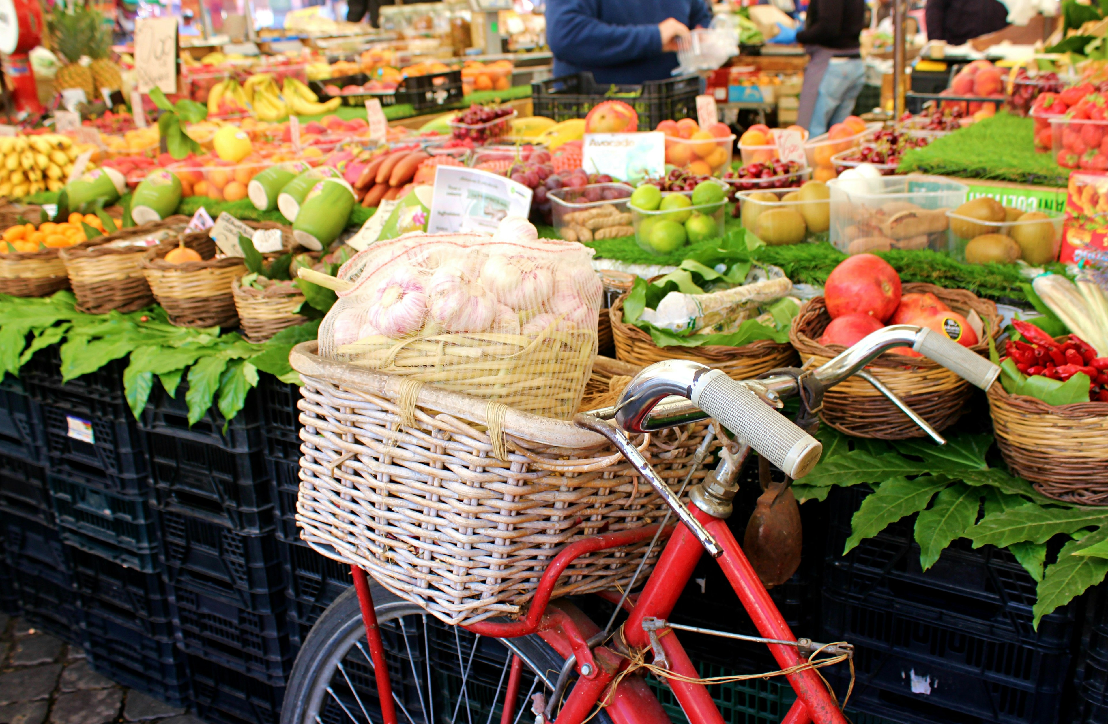 Un vélo rouge garé à côté d’un étalage de fruits et légumes photo ...