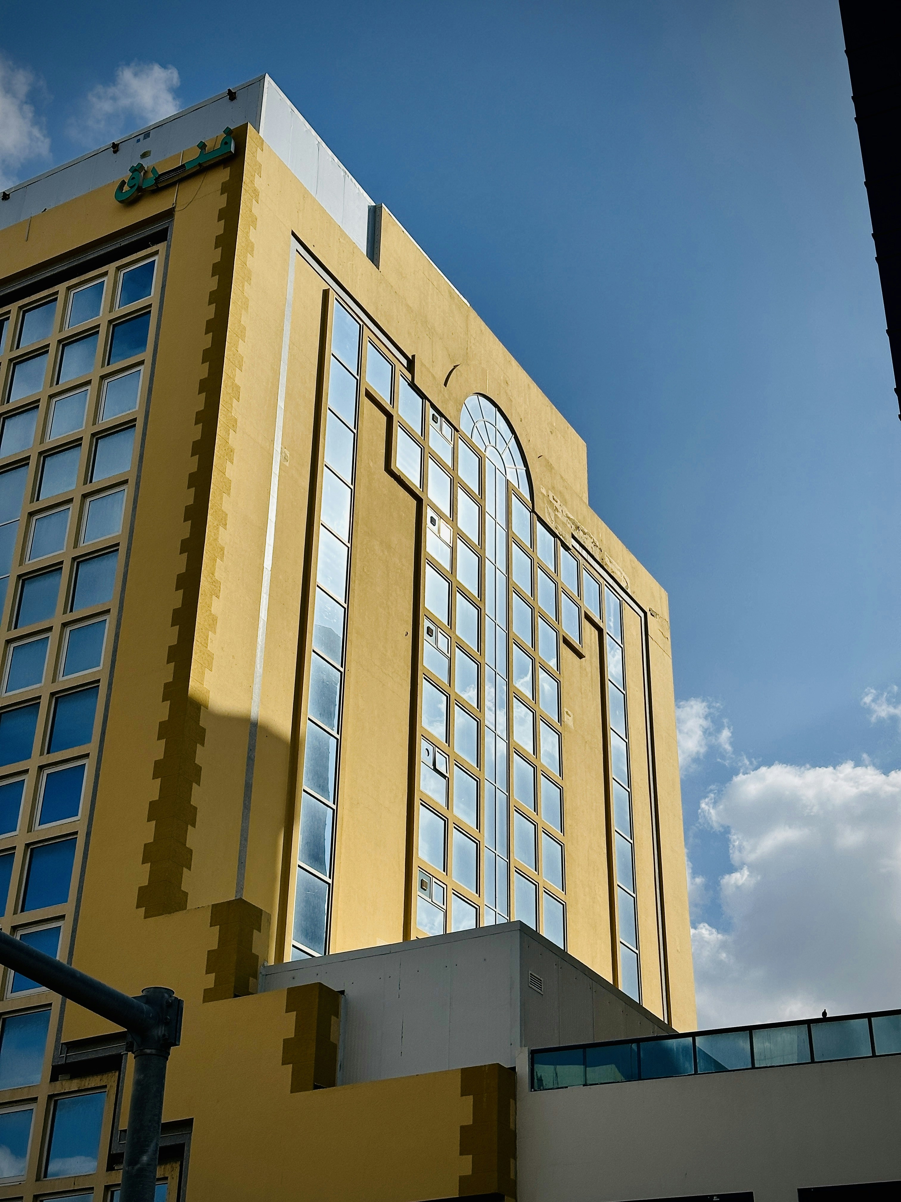 A tall yellow building with a clock on it's side photo – Free Building ...