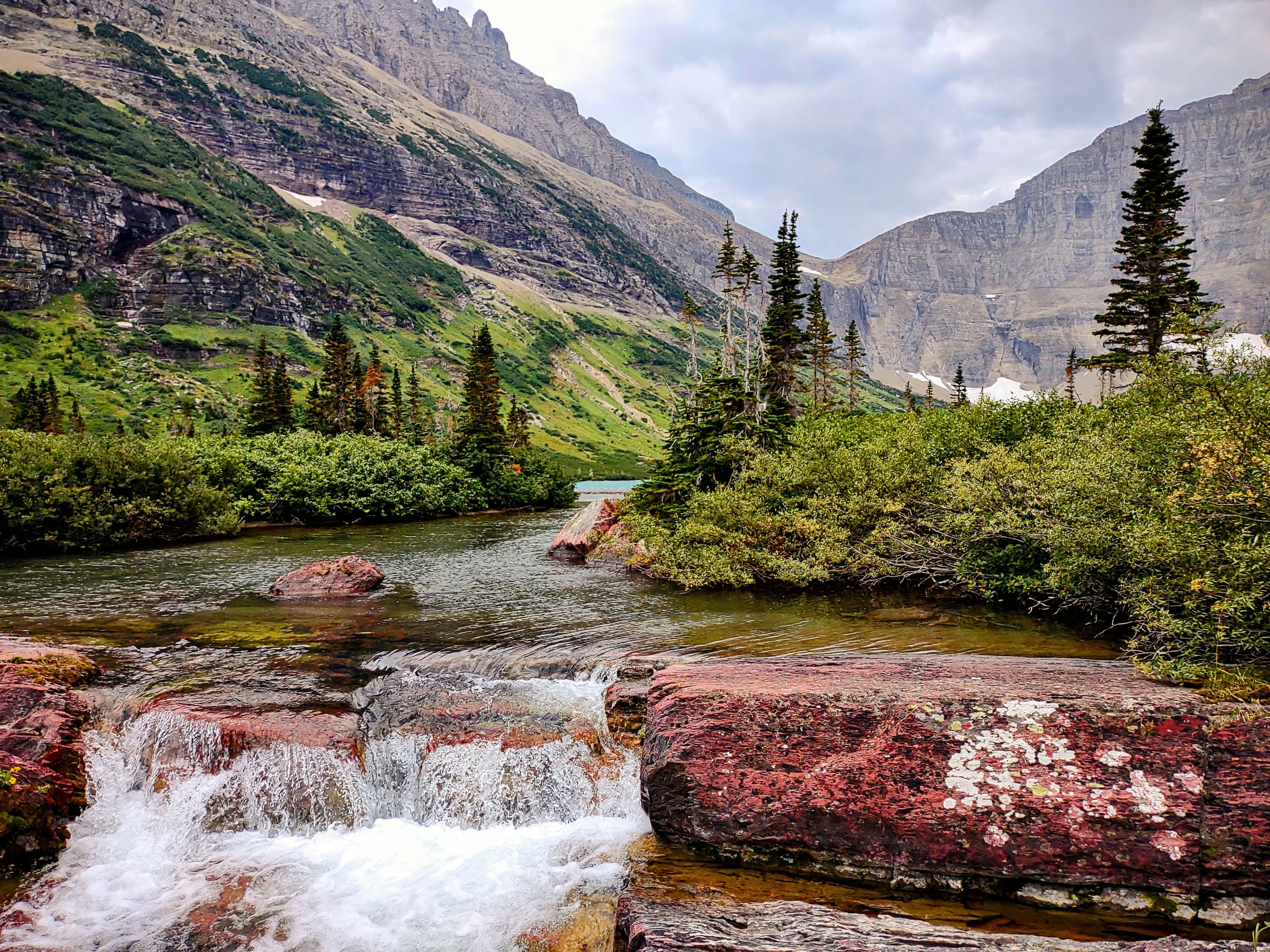 Crimson Rock Cascades Under Alpine Peaks