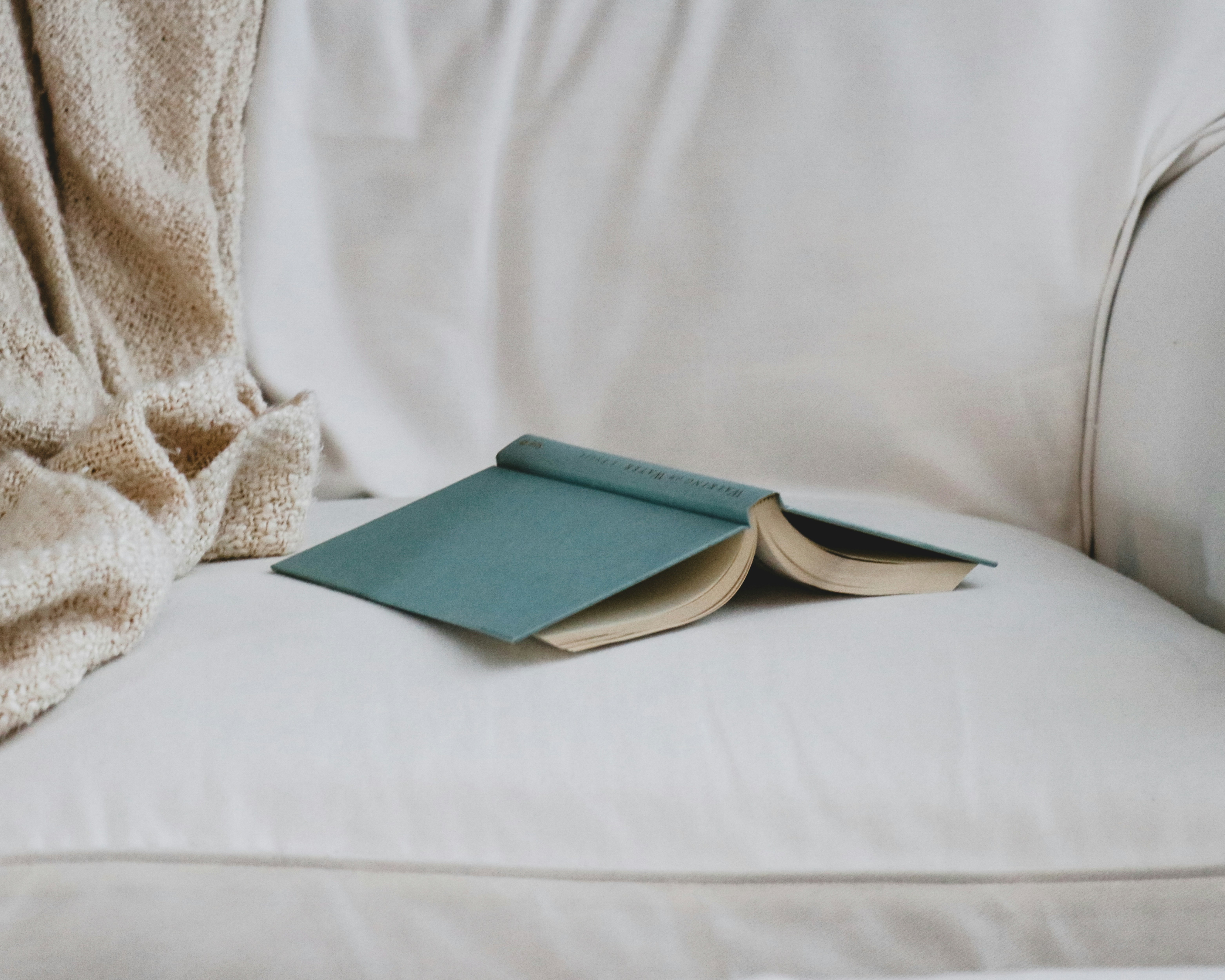 An open book sitting on top of a white couch photo – Free Meditation ...