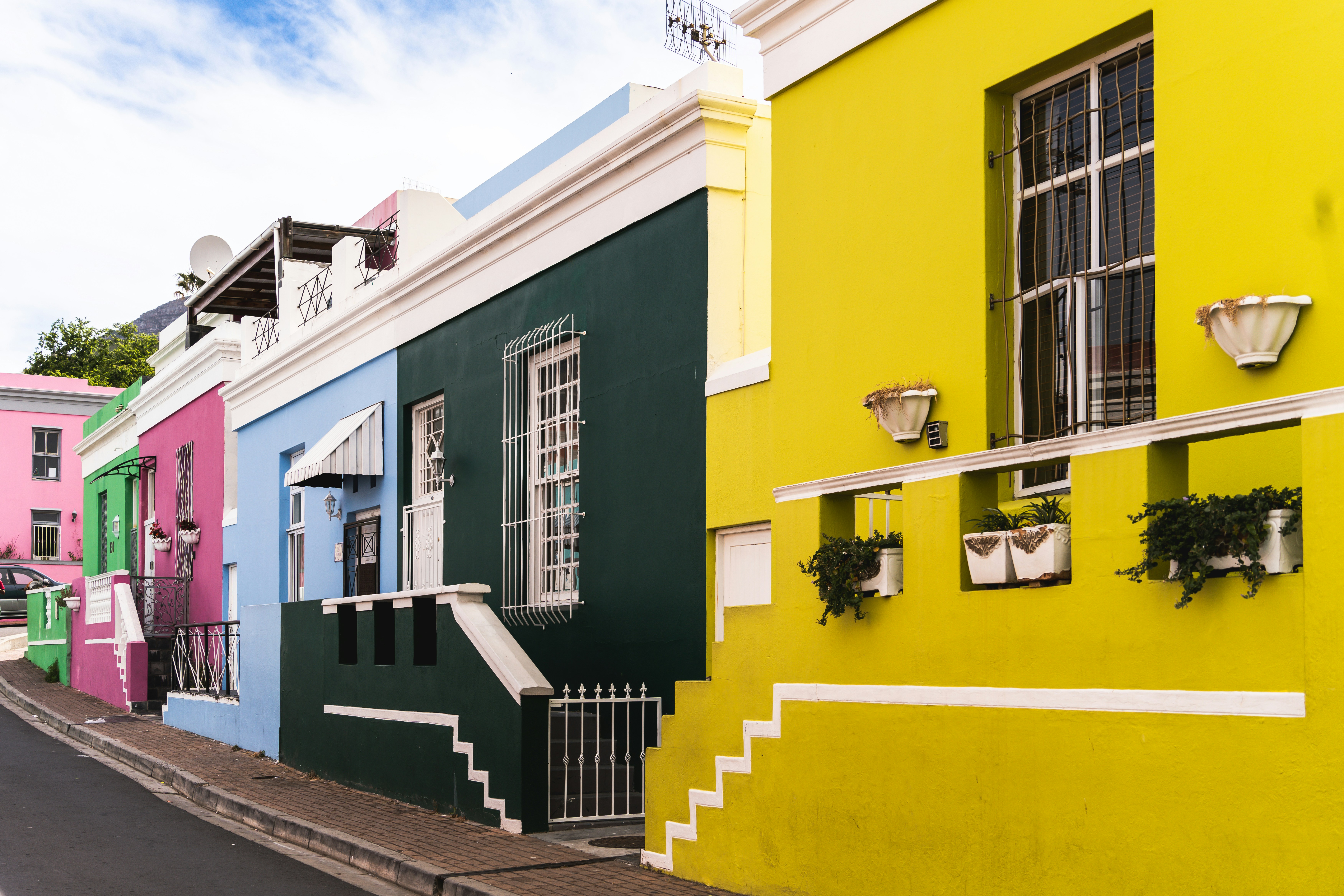 A row of brightly colored houses on a street photo – Free Housing Image ...
