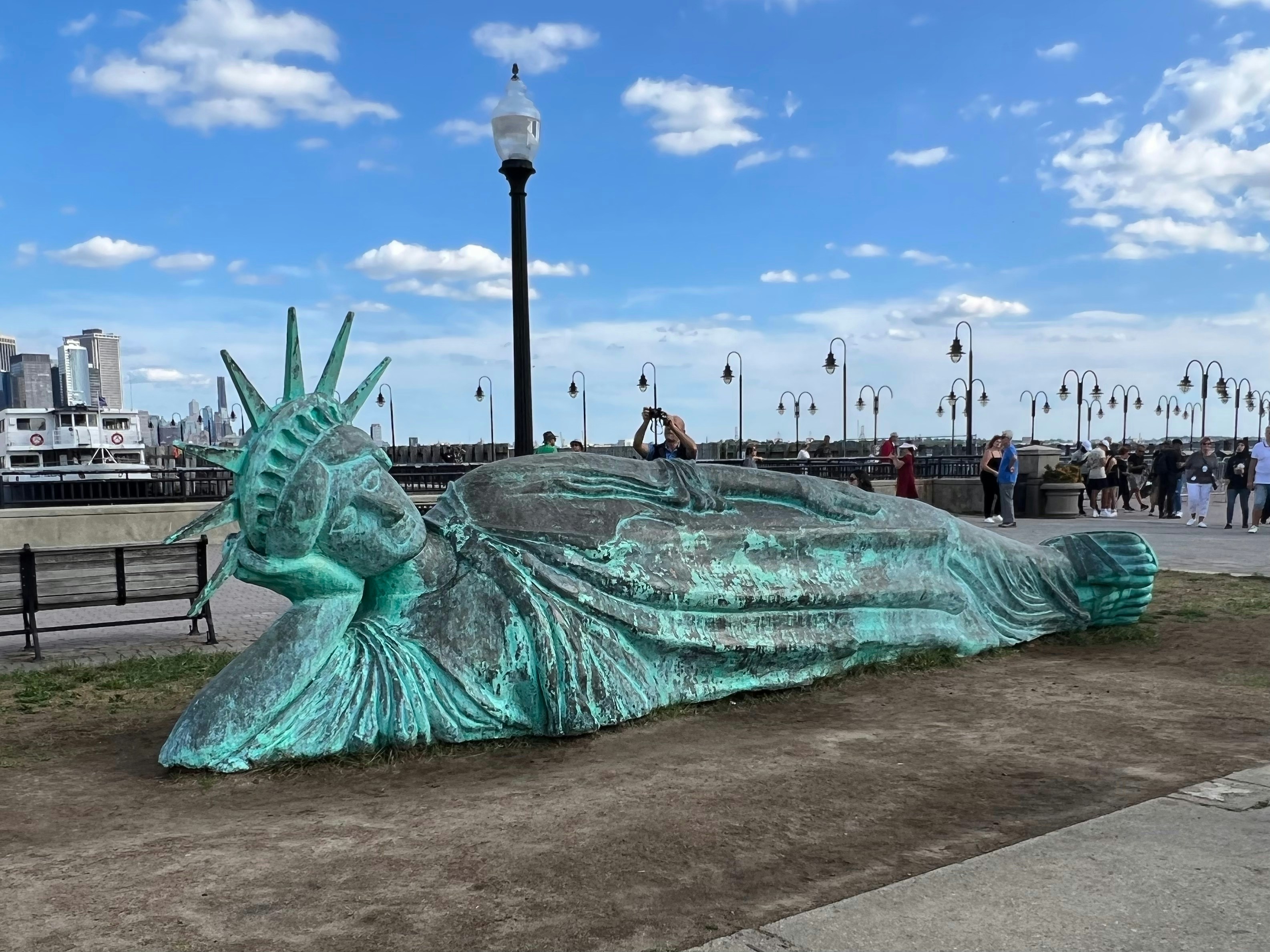 The Reclining Liberty: a riverfront sculpture under a clear sky