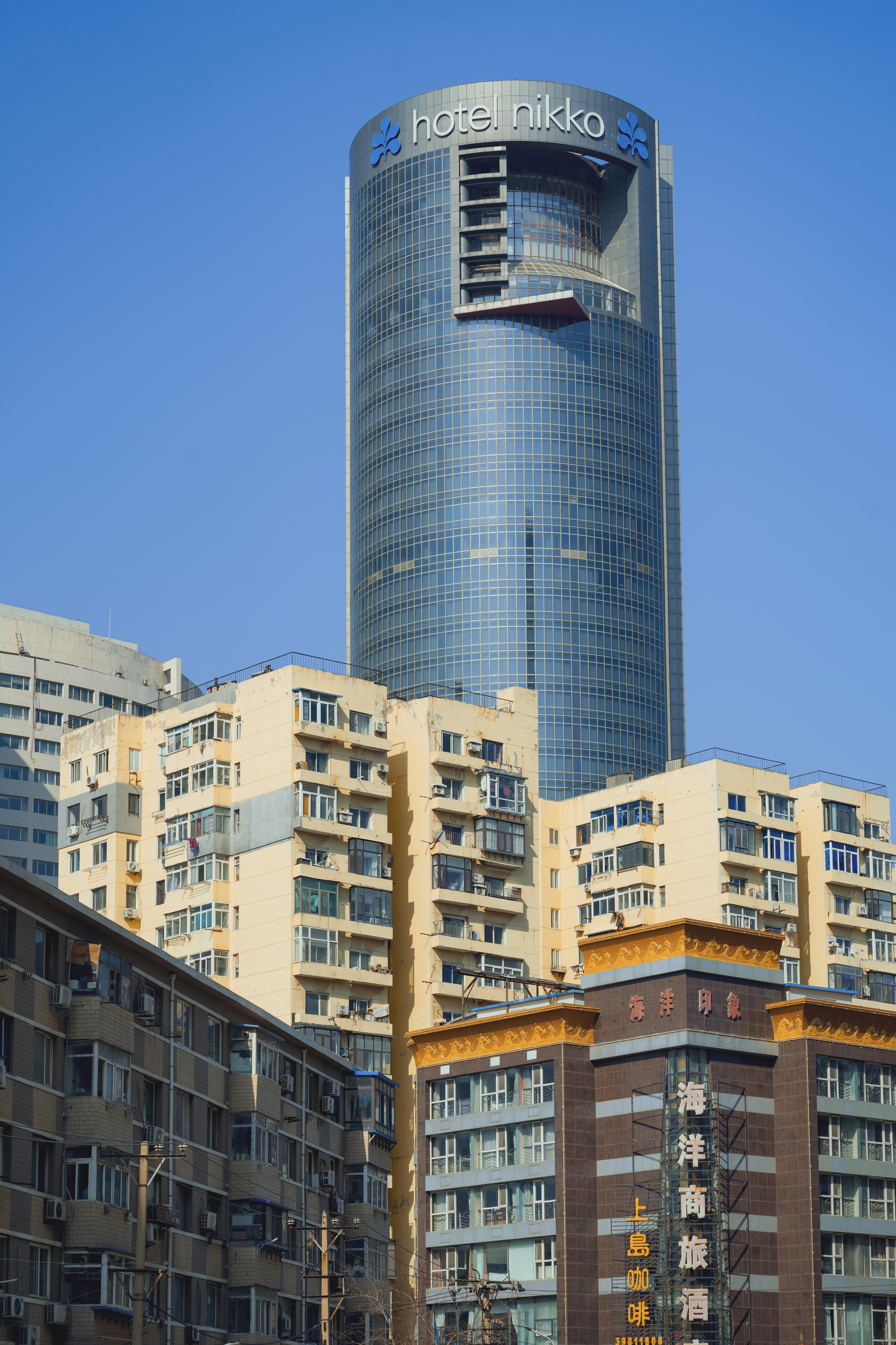 Tall Blue Veil: The Nikko Hotel Rises Over a Sea of Residential Blocks