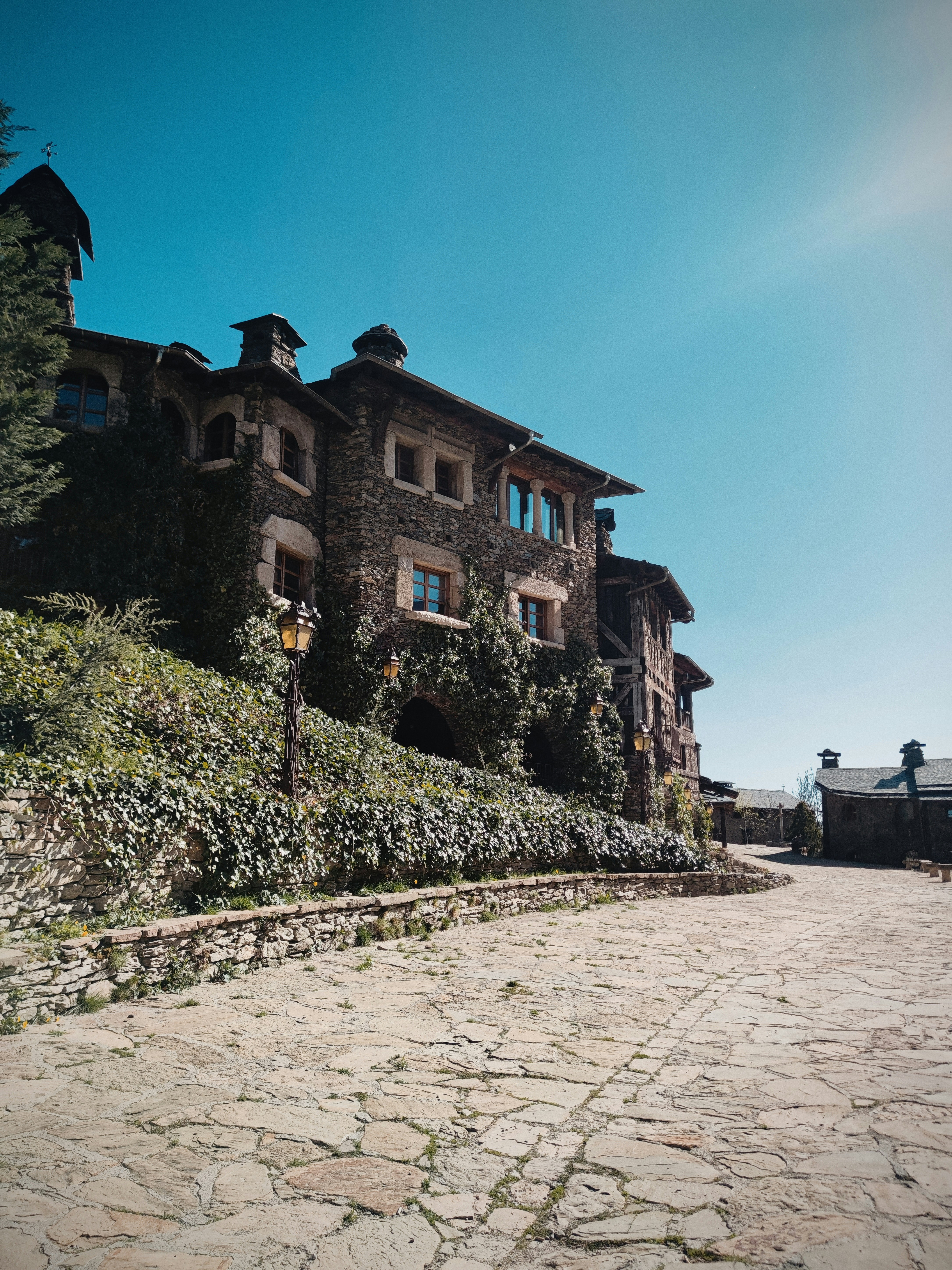 A stone road with a building on the side of it photo – Free Auvinyà ...