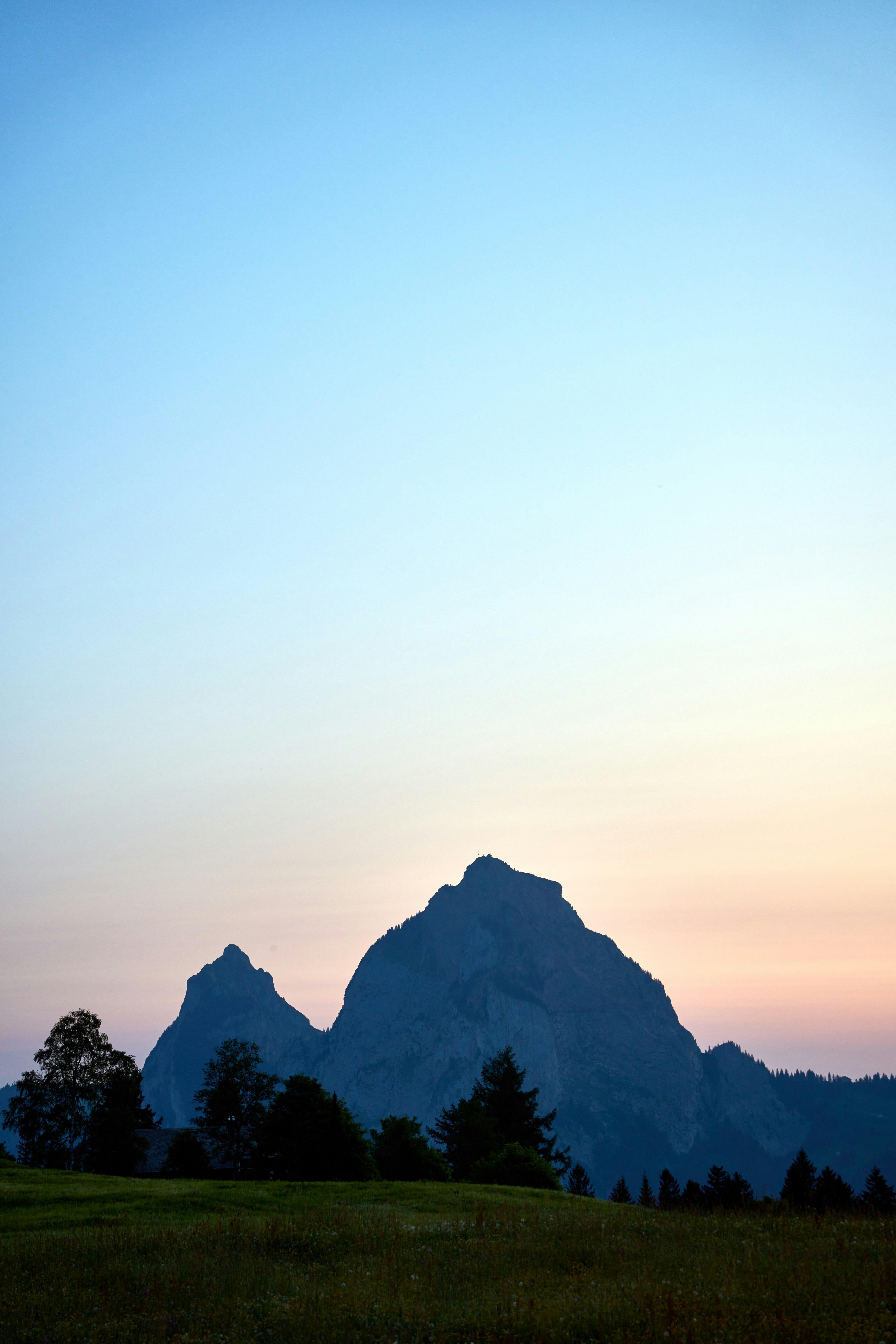 A grassy field with a mountain in the background photo – Free Blue ...