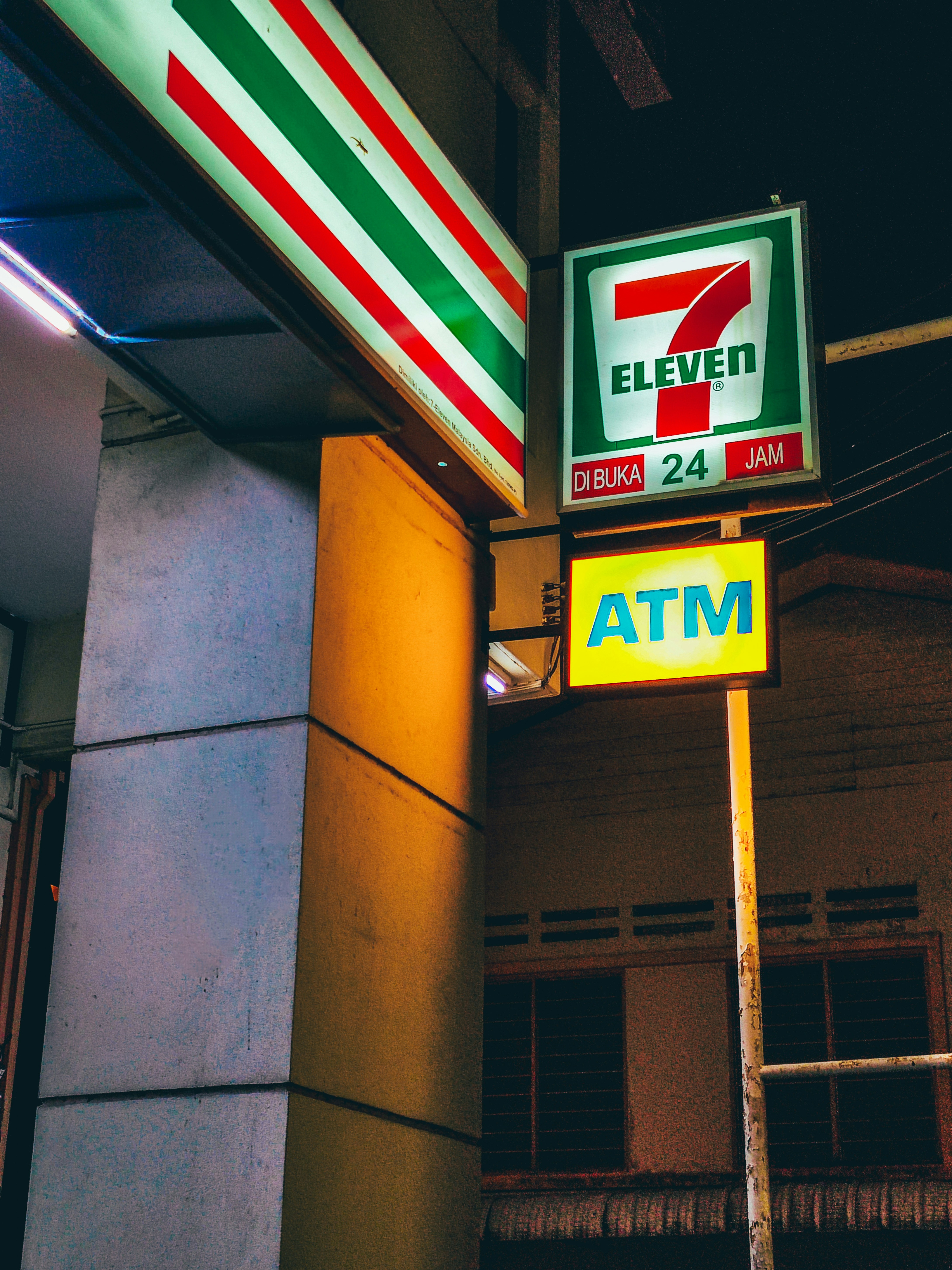7Eleven | a sign for a gas station on the side of a building