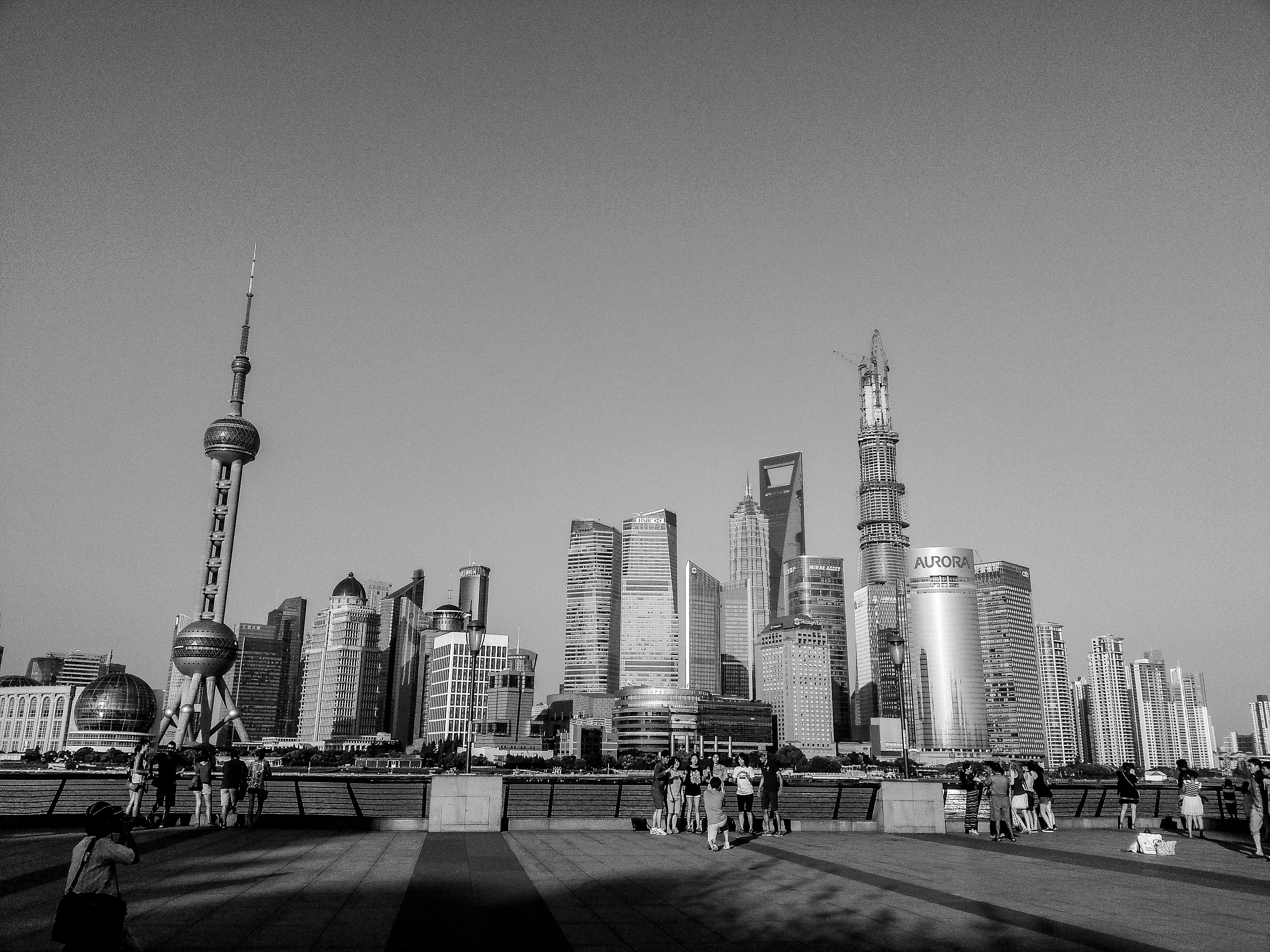 Monochrome view of Shanghai's Bund showcasing historic European architecture against modern skyscrapers.