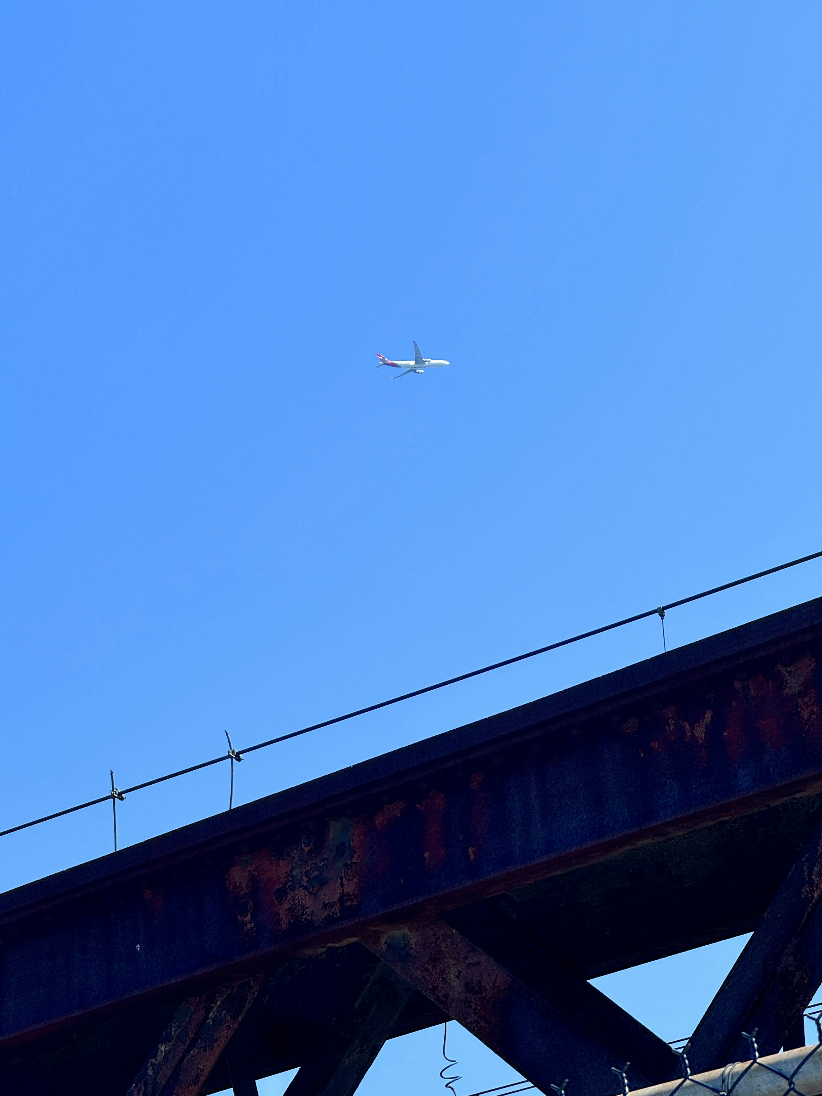 An airplane is flying over a bridge on a clear day photo – Free ...