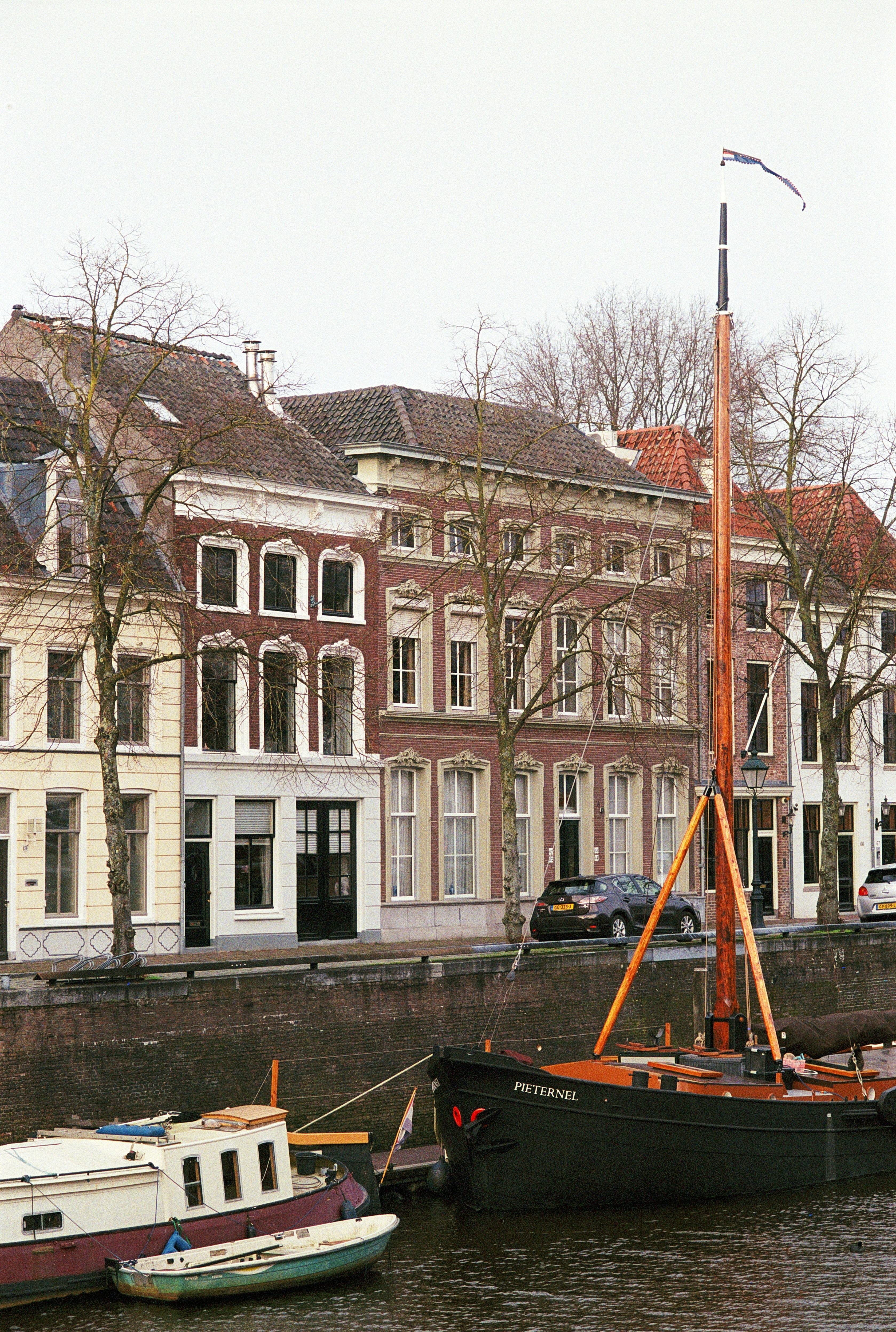 Orange Mast Rising Over Dutch Canal Front