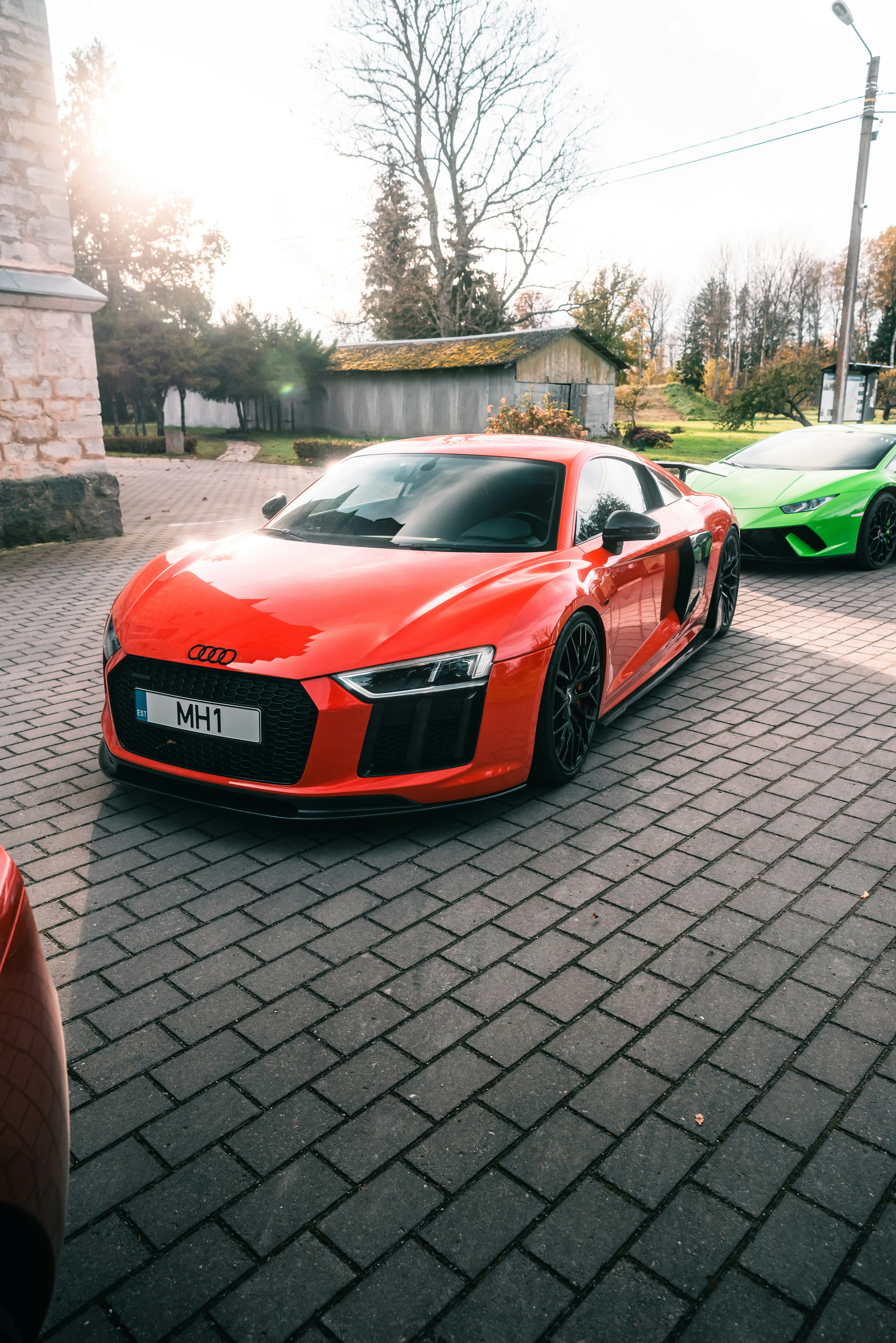 A couple of cars parked next to each other on a brick road photo – Free ...