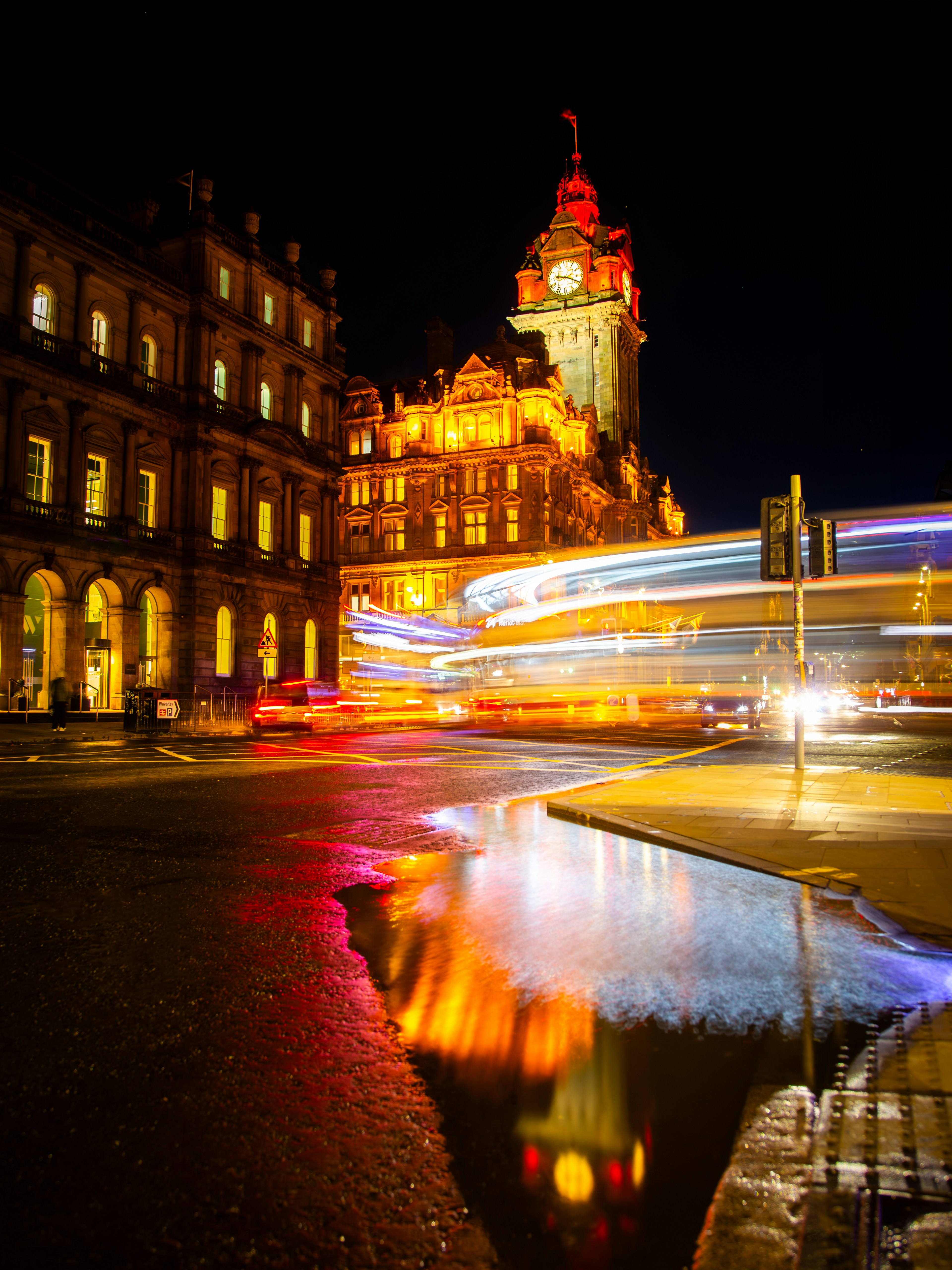 Glowing Clocktower Over a City at Night with Light Trails