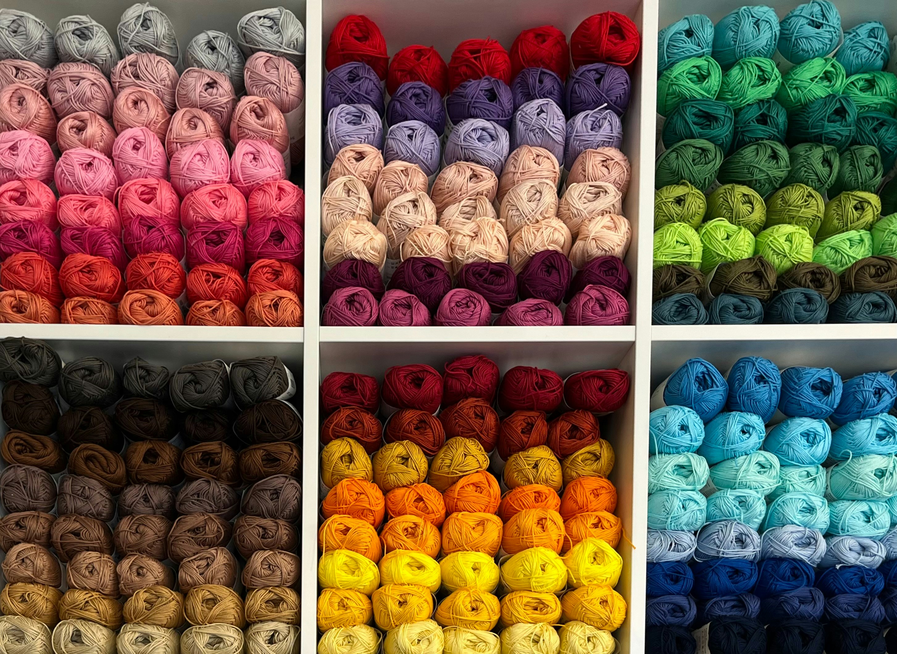 A shelf filled with lots of different colored balls of yarn photo ...