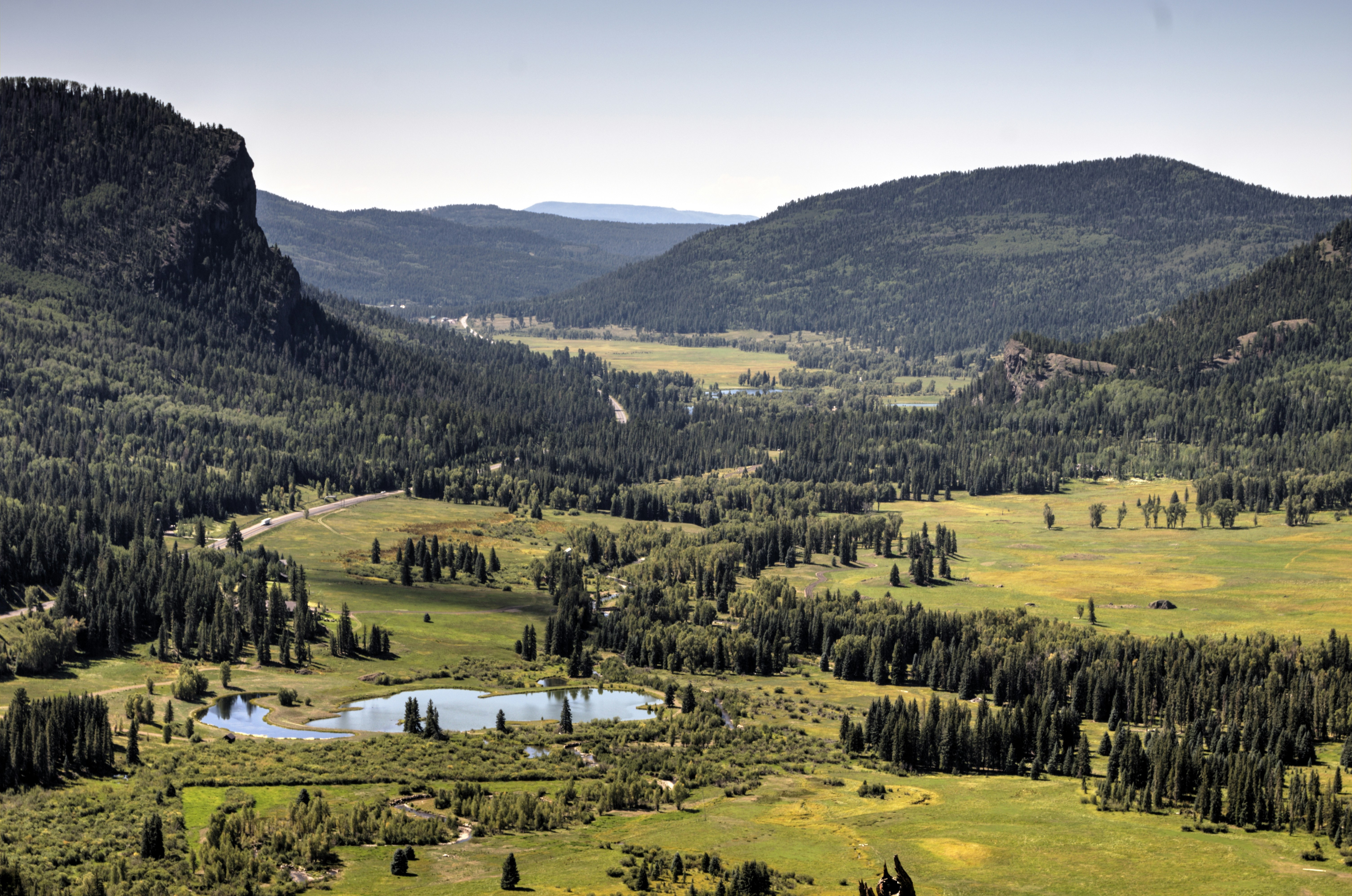 A scenic view of a valley with a lake in the middle photo – Free Wolf ...