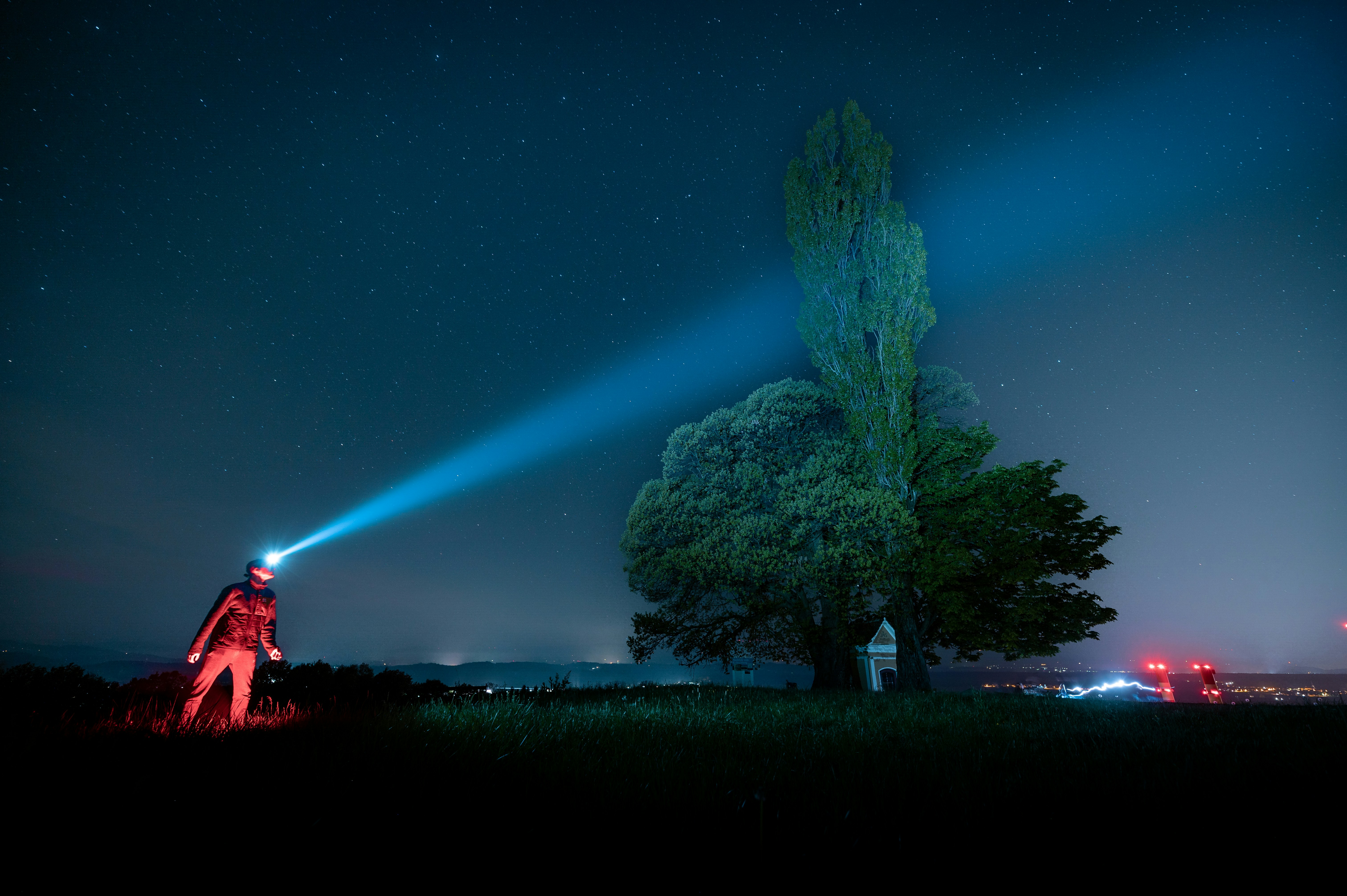 A person standing in a field with a flashlight in their hand photo ...