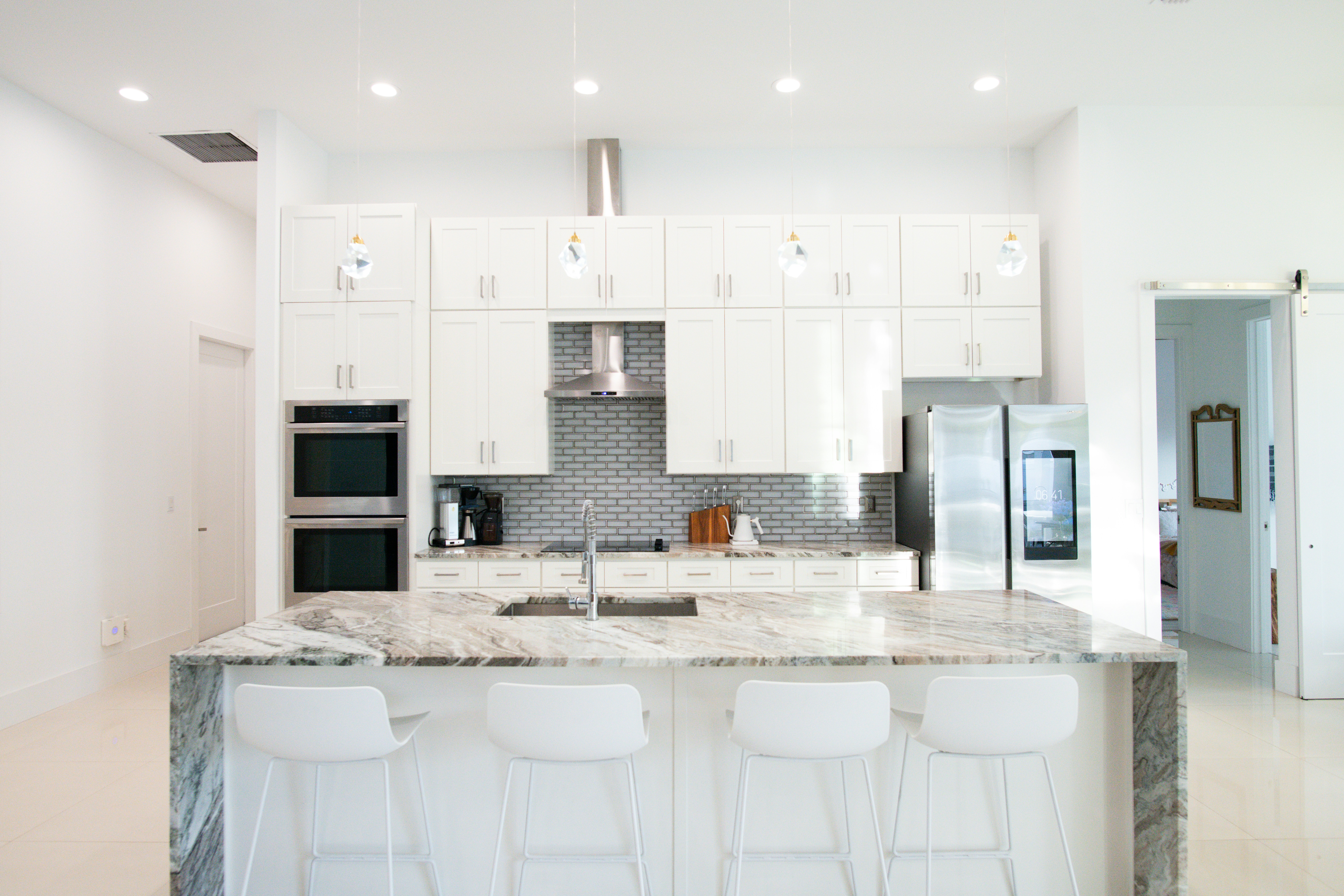 A kitchen with white cabinets and marble counter tops photo – Free ...