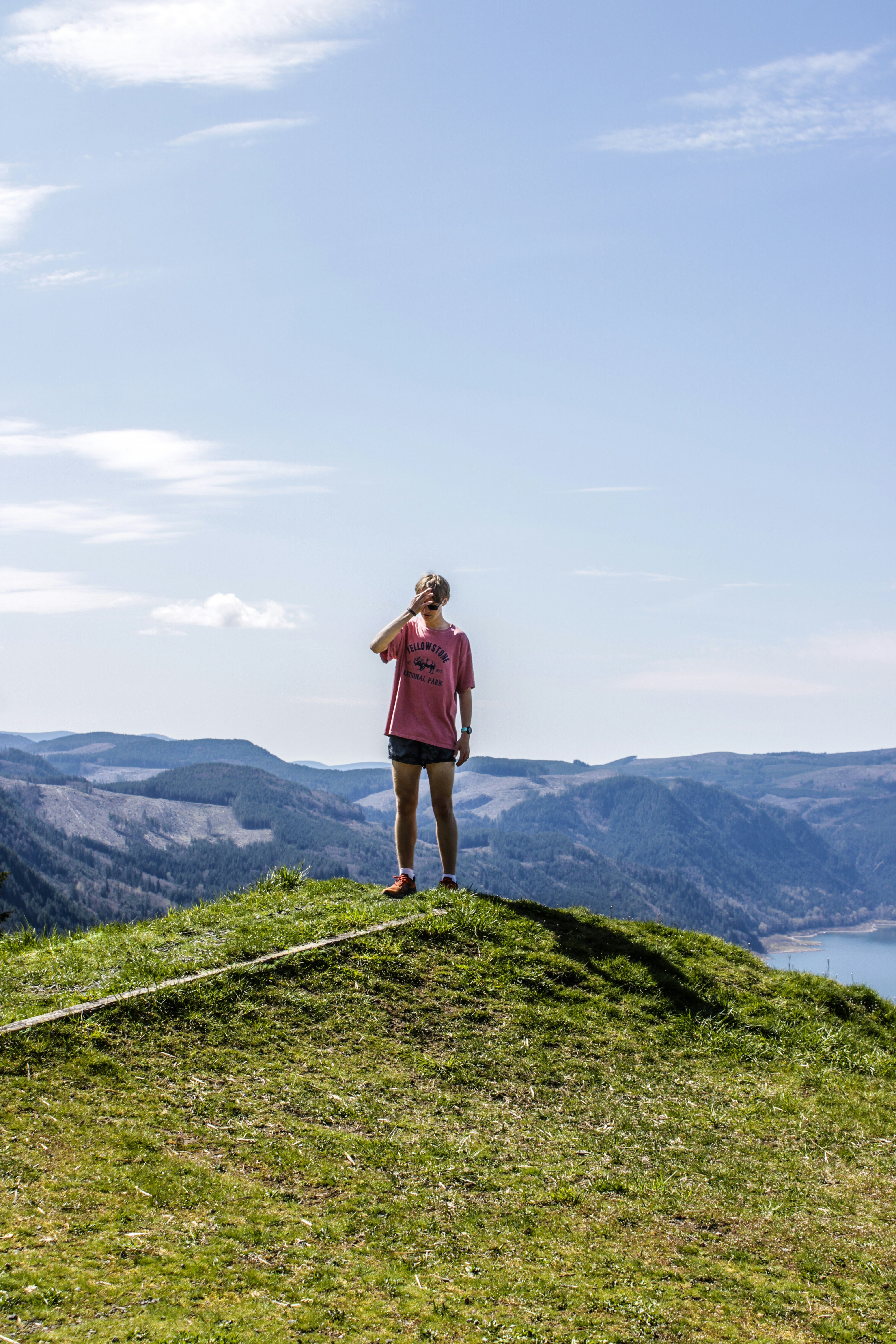 Pink-clad Hiker on the Ridge Overlooking Distant Valleys