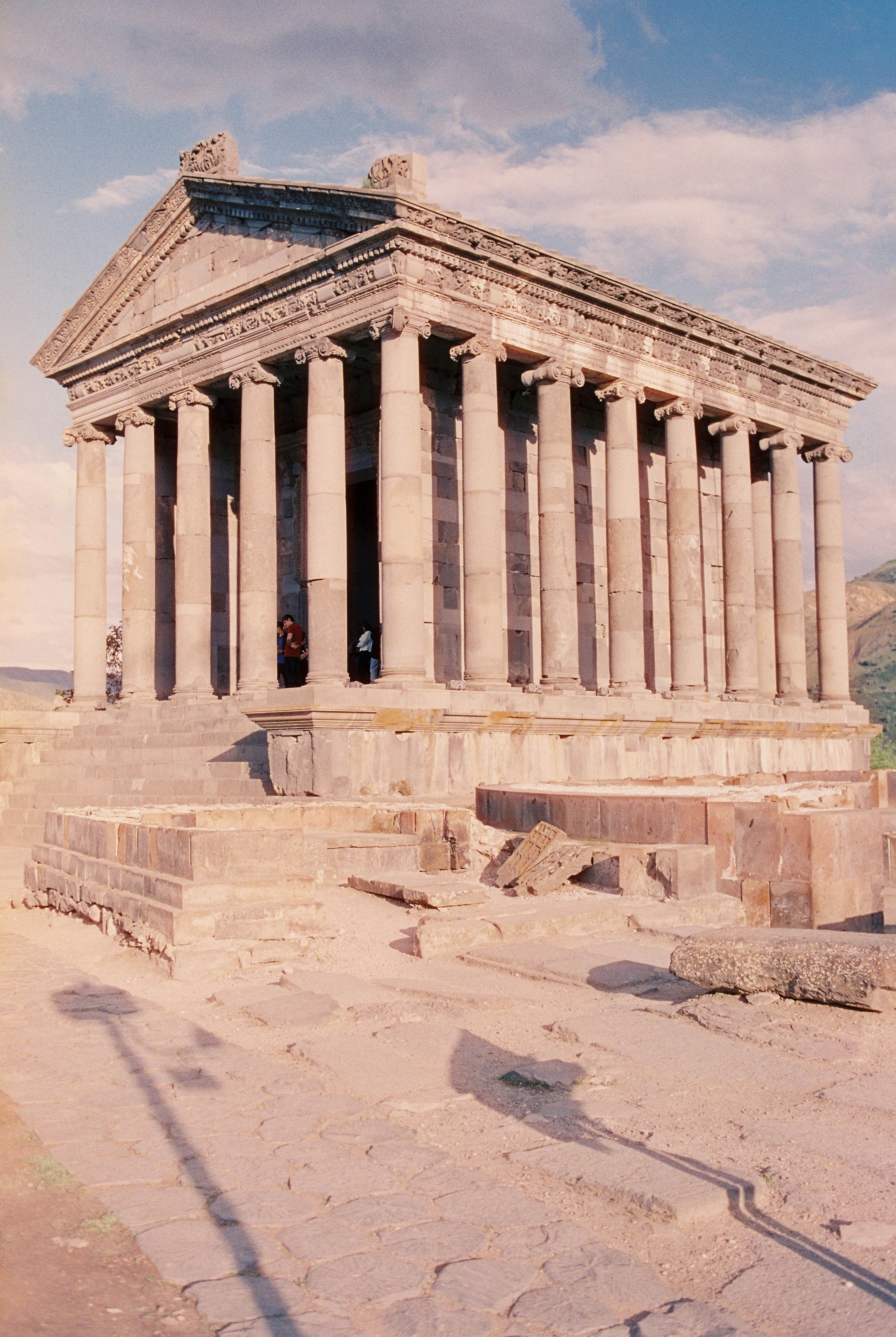 A large stone building with columns and a man standing in the doorway ...