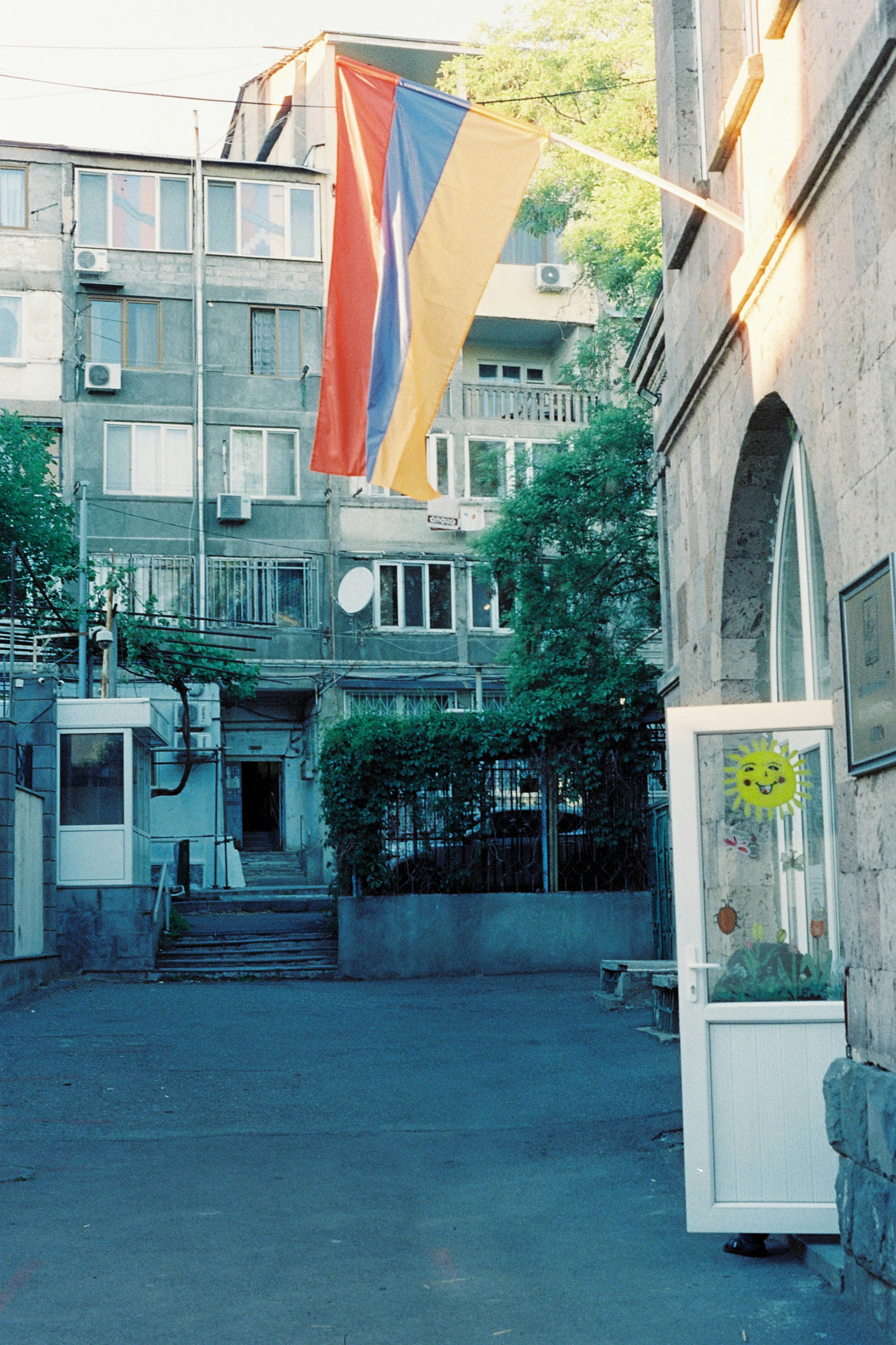 Vertical Tricolor Over a Quiet City Courtyard