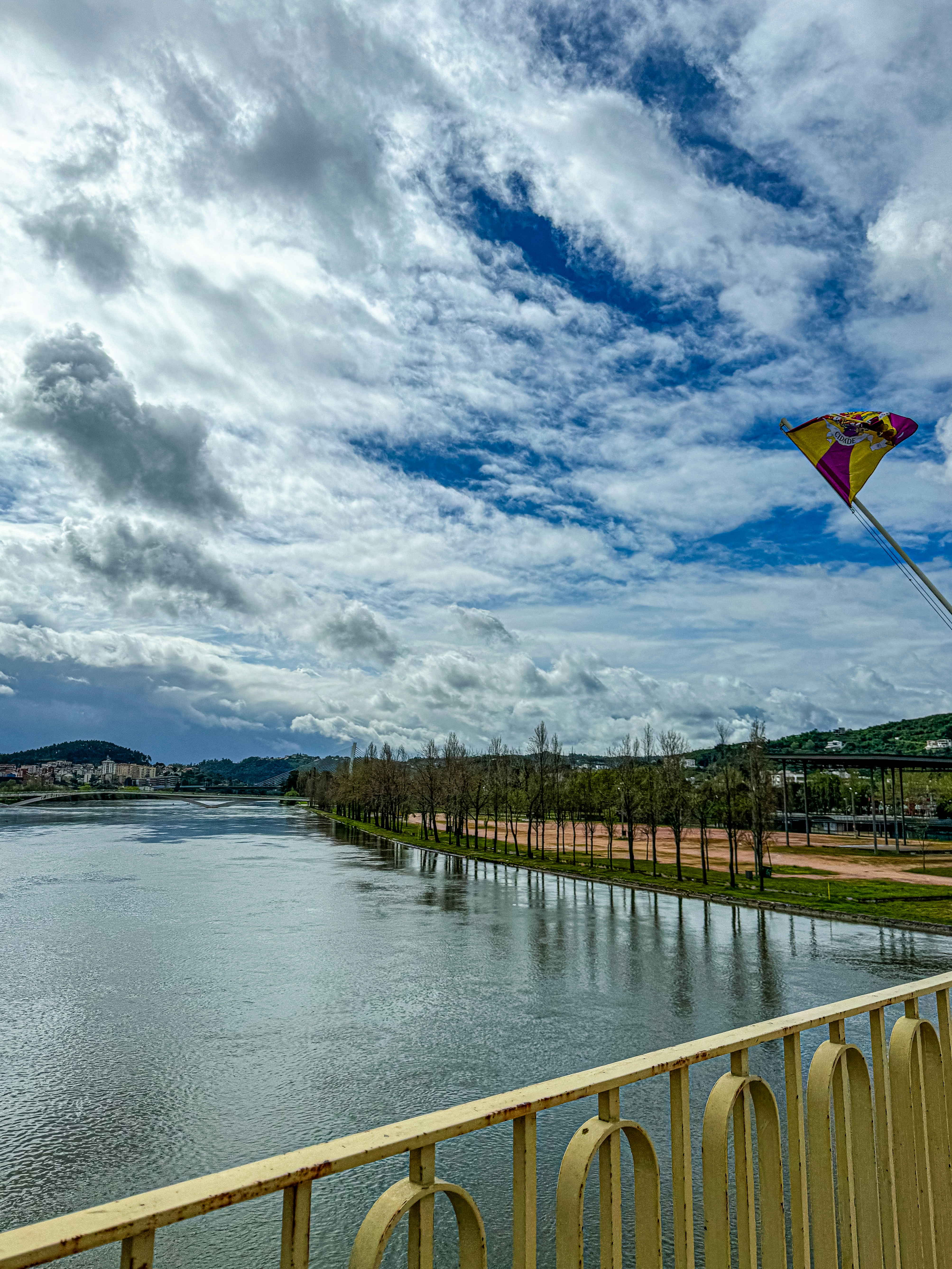 Kite Against a Patchwork Sky Along the Riverside Promenade