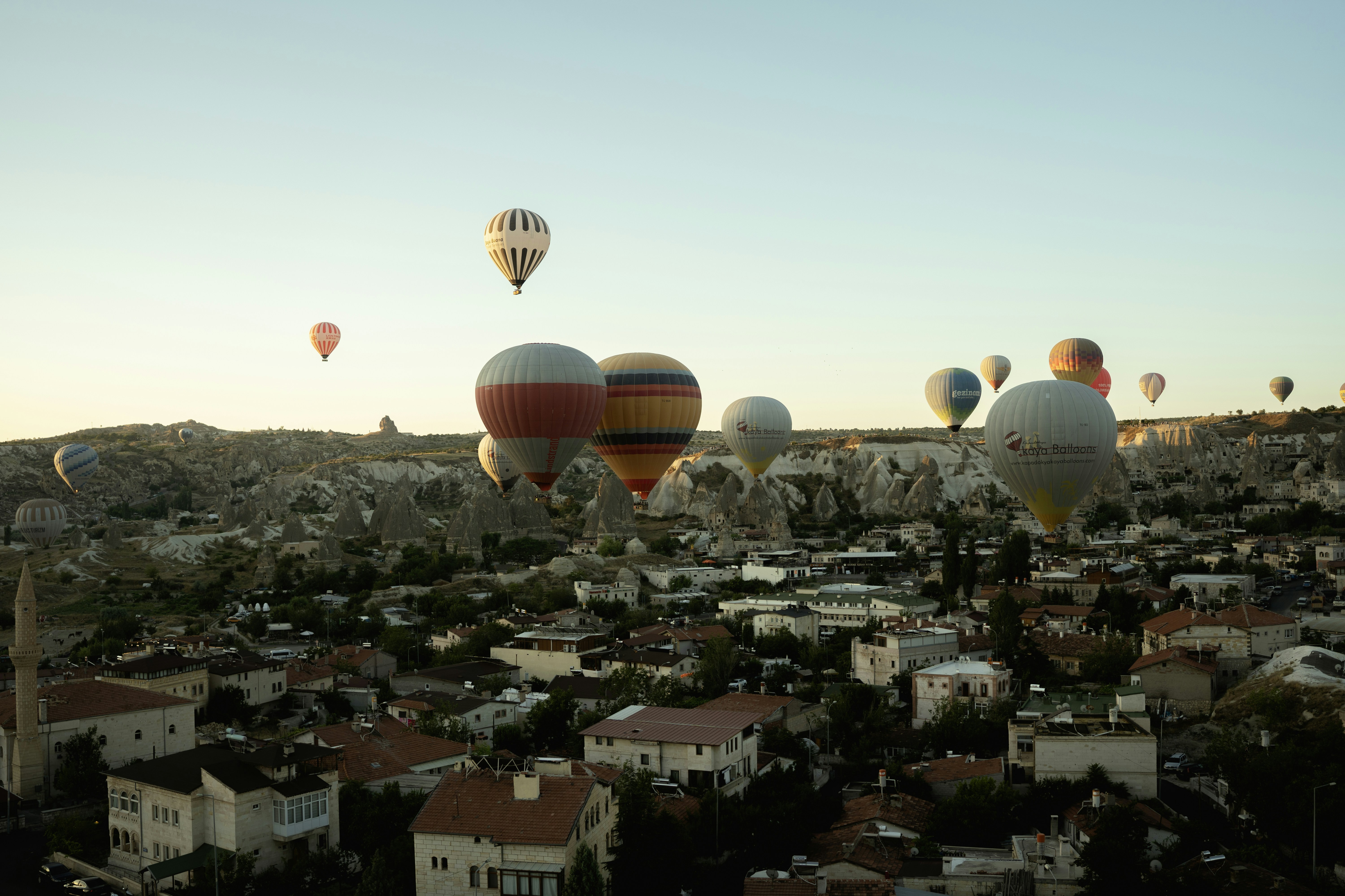 Dawn Flotilla Over a Hilltown: Balloons Above Red Tile Roofs