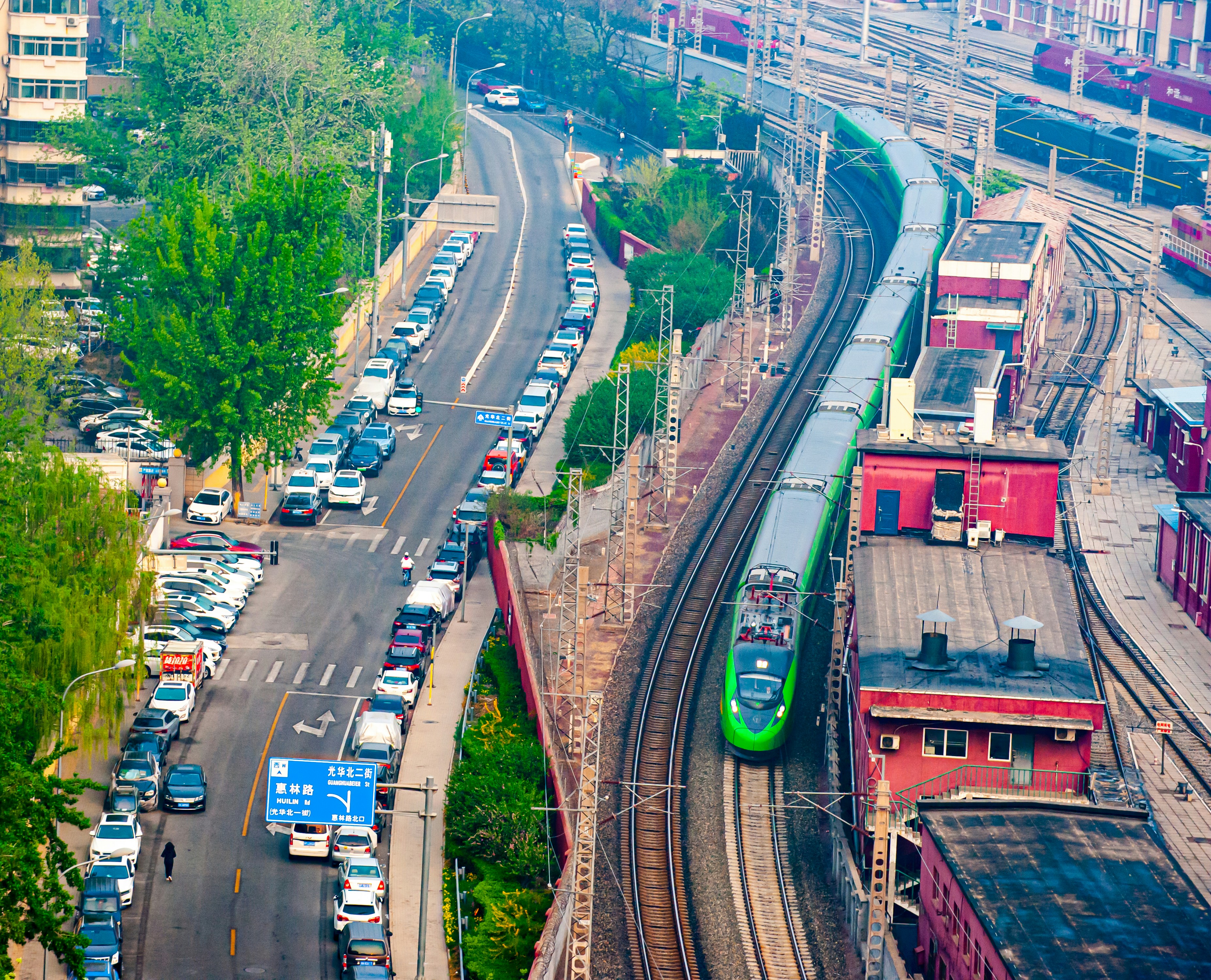 A train on a train track next to a busy street photo – Free Railway ...