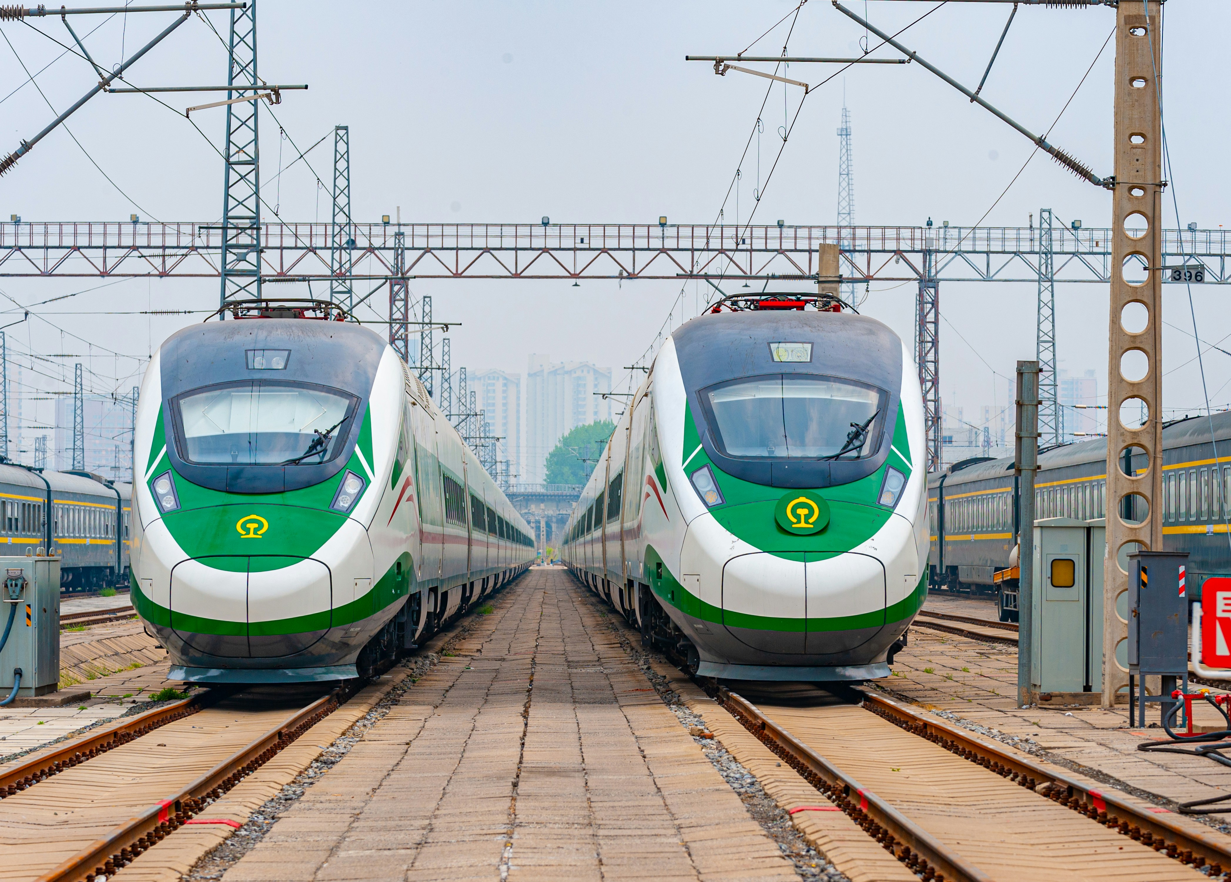 Two green and white trains sitting on train tracks photo – Free Train ...