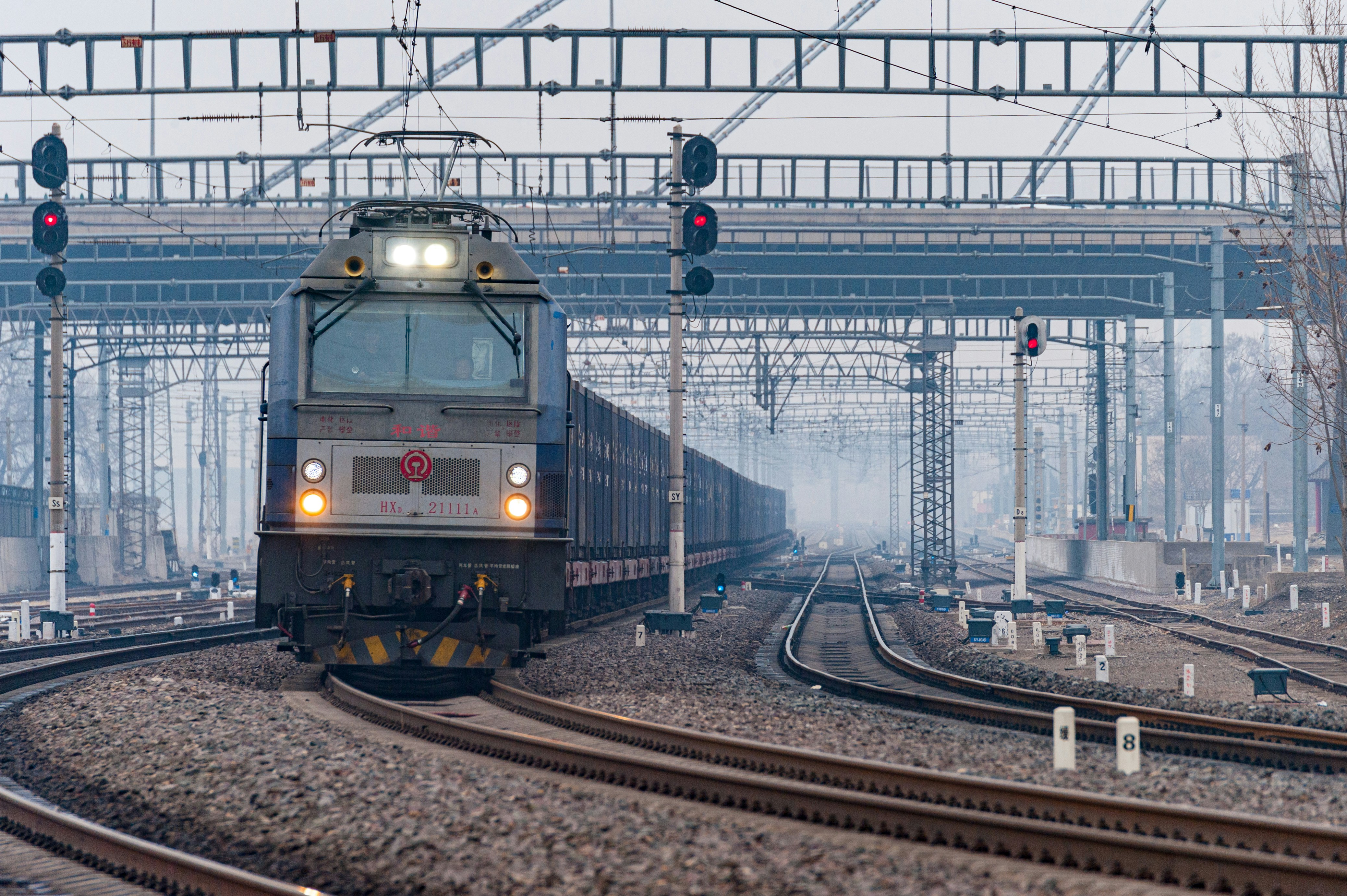 A train traveling down train tracks under a bridge photo – Free Train ...