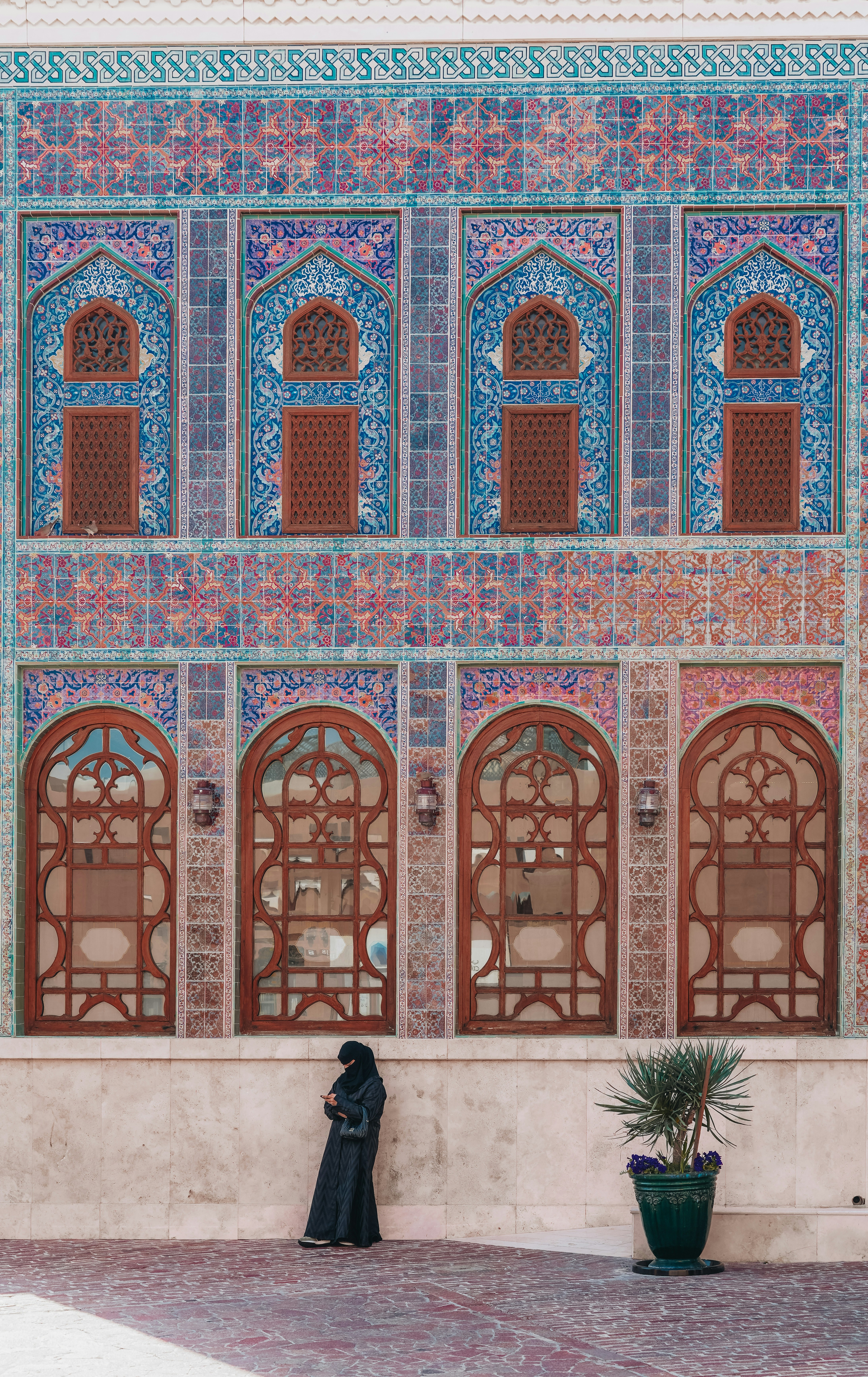 Quiet Figure Against a Cerulean Mosaic Facade