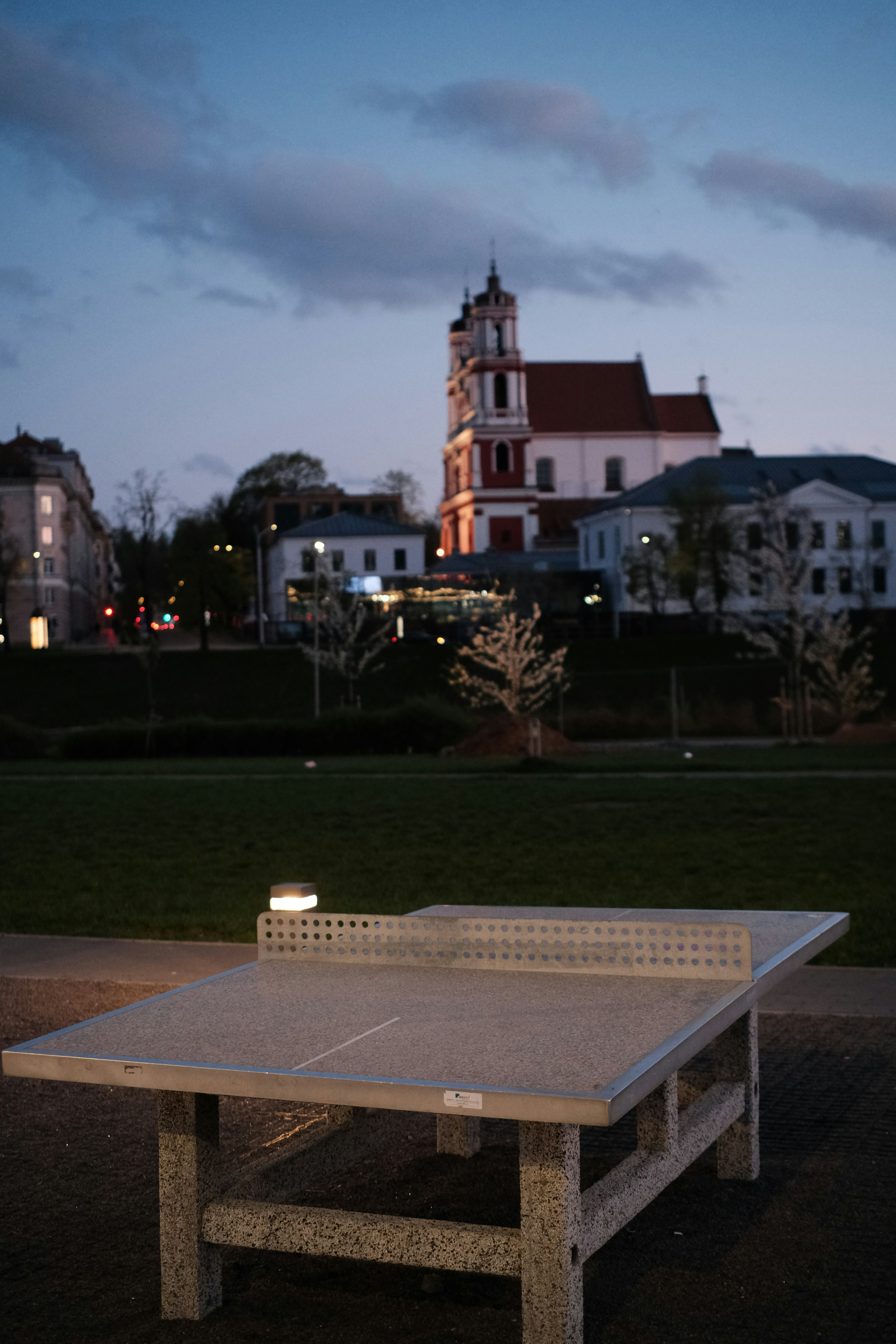 Dusk at the Park Table: A Quiet Ping-Pong Moment Framed by a Historic Church