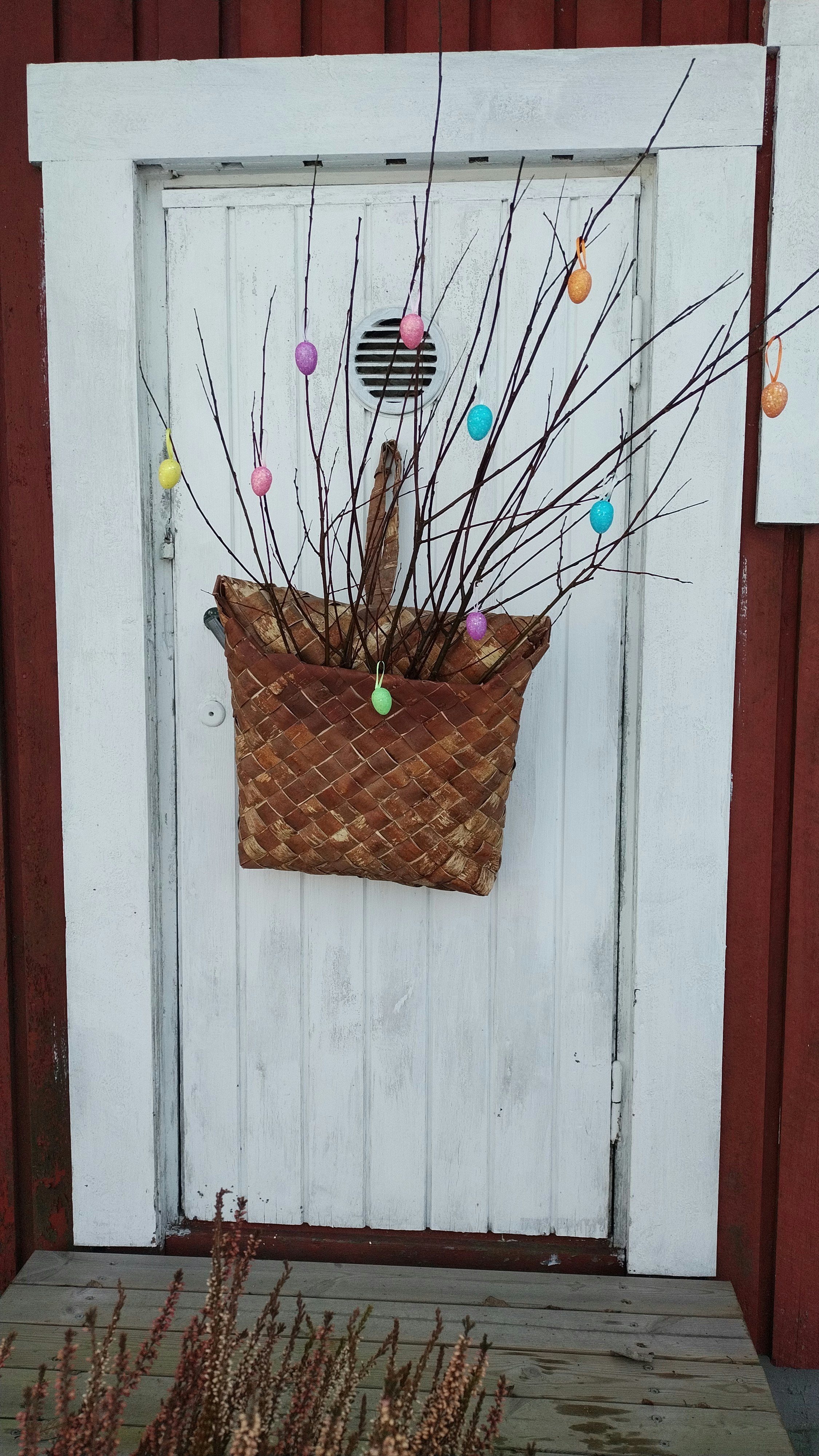 Easter Branches in a Basket: A White Door Backdrop withColorful Ornaments