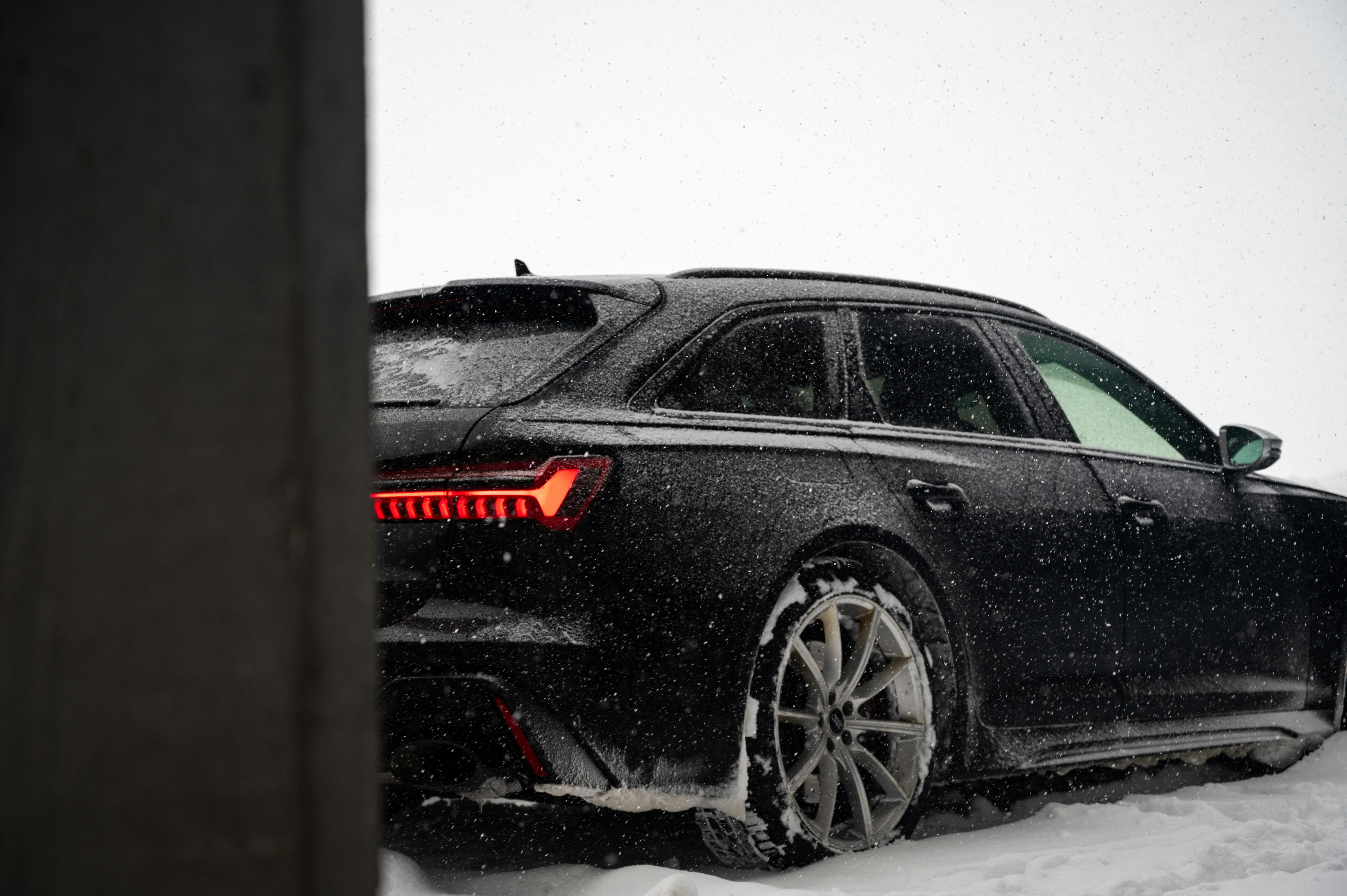 Snowbound Stance: A Black Luxury Sedan Quietly Rests in a Snowfall.