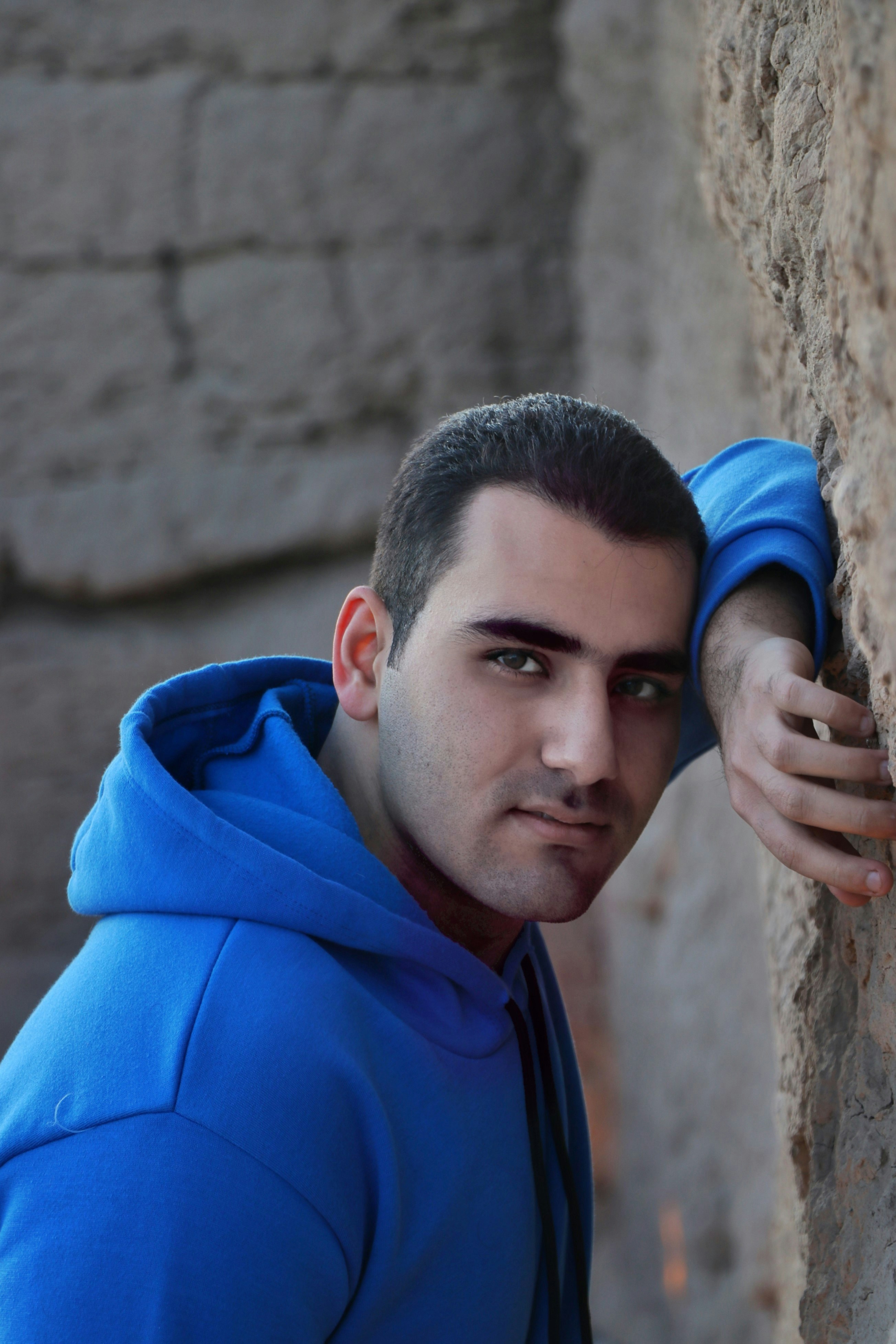 Azure Hoodie Portrait: Quiet Gaze by Weathered Stone