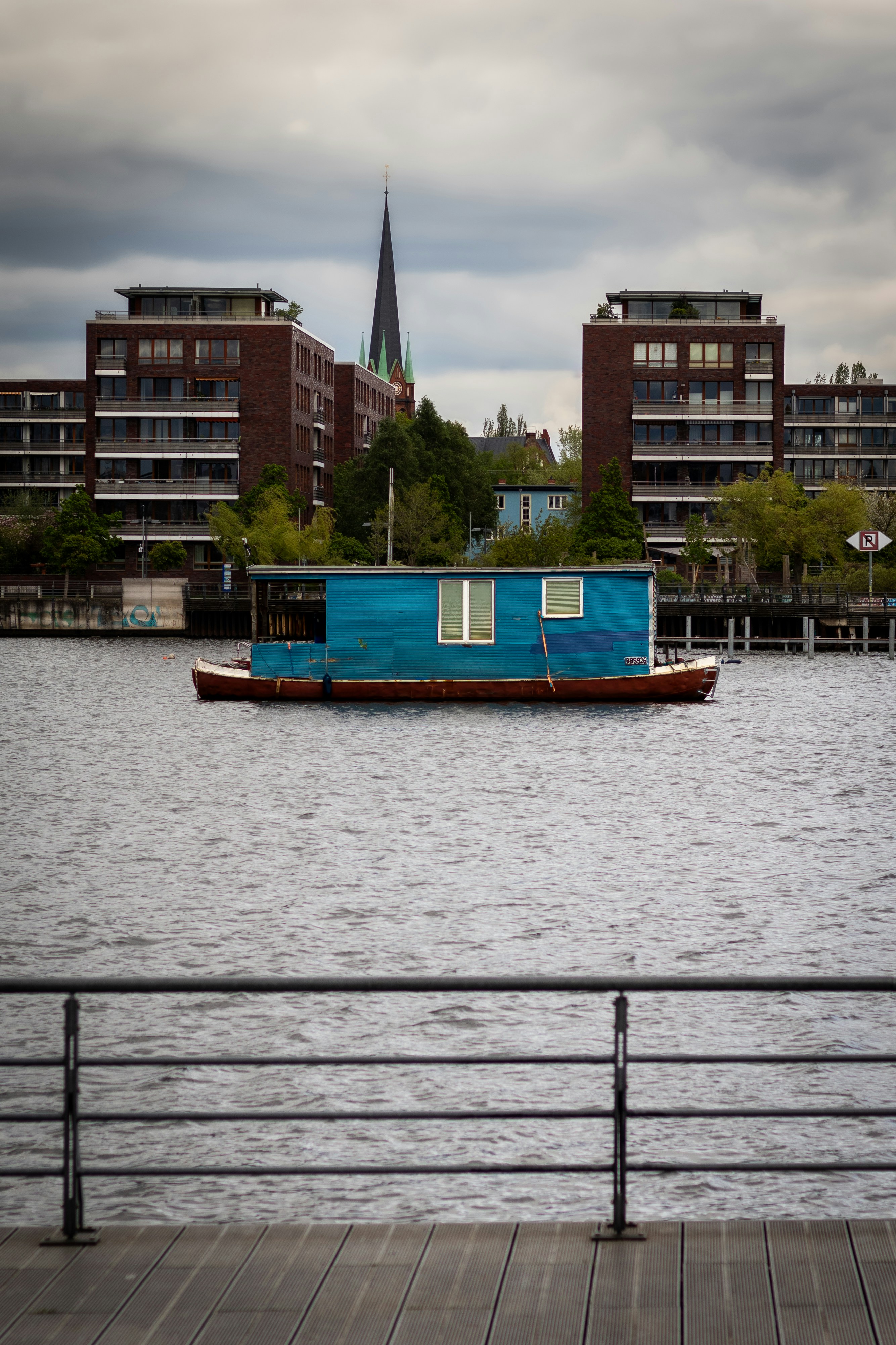 Azure Houseboat on a City River Beneath a Stately Spire