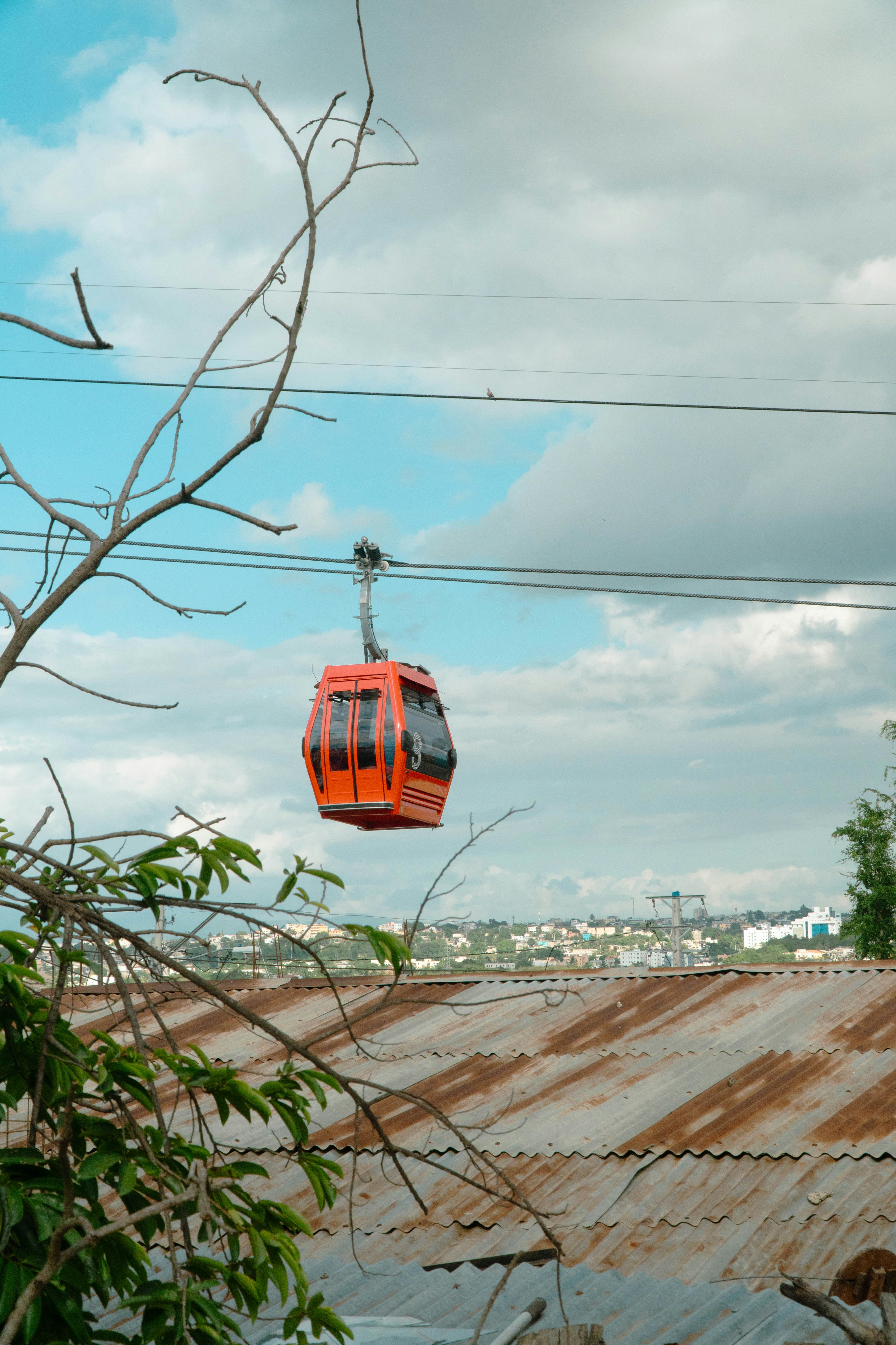 Orange Cable Car Above a Rusted Rooftop: A Quiet City Moment